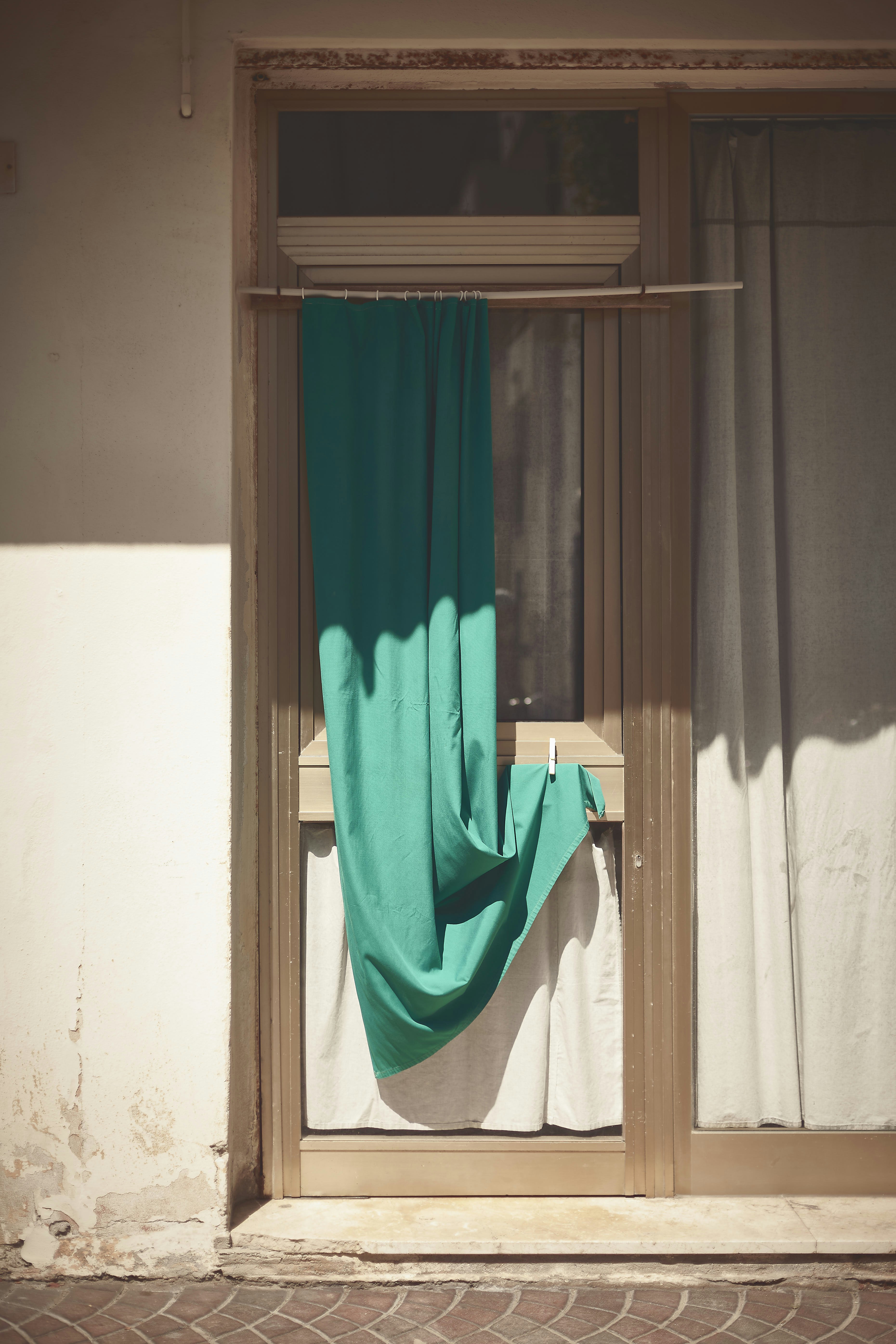 Teal Curtain at the Threshold: Light, Shadow, and Texture in a Sunlit Doorway