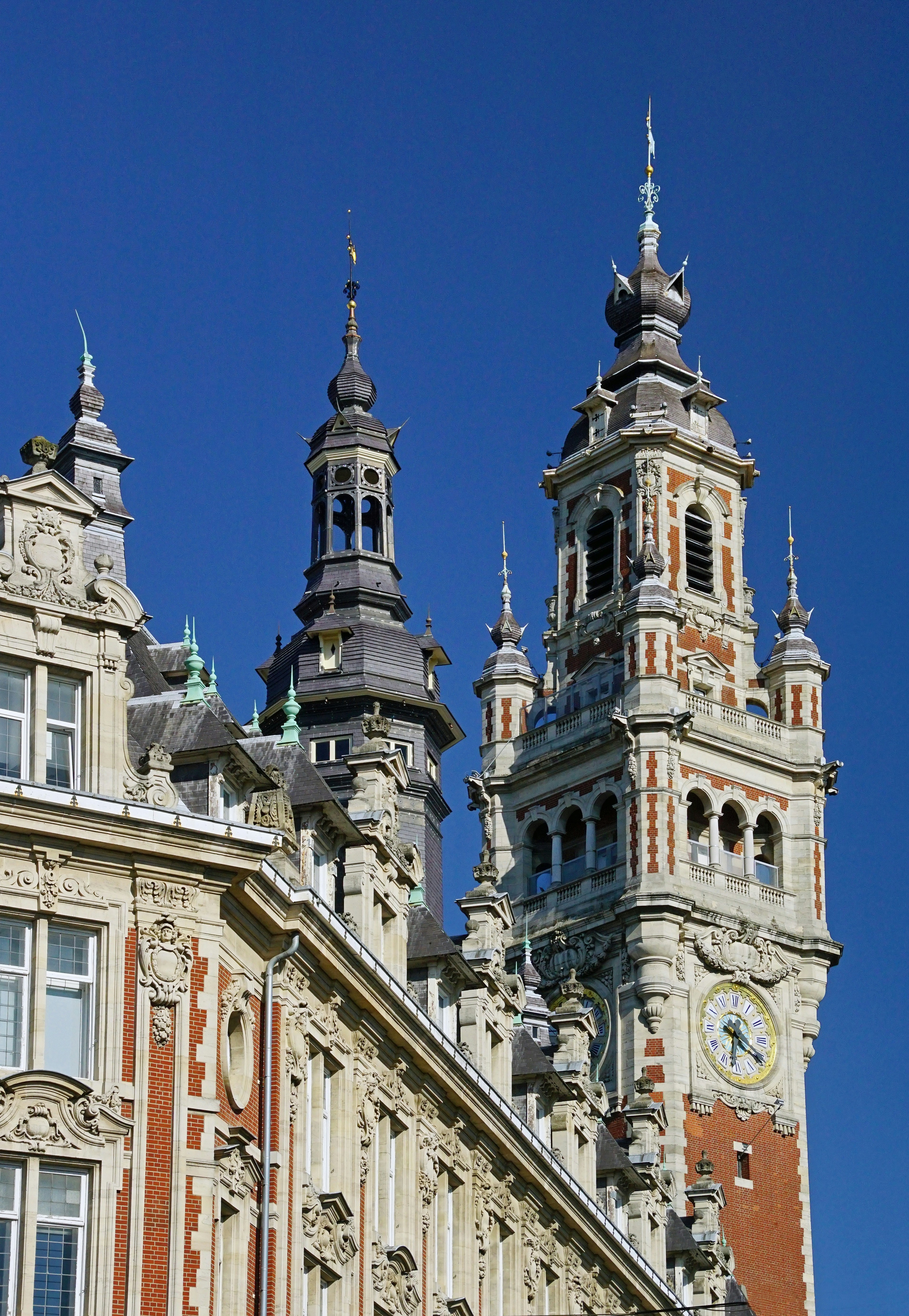 The old tower of the Chamber of Commerce of Lille, France with another old building in the front on a sunny summer day.