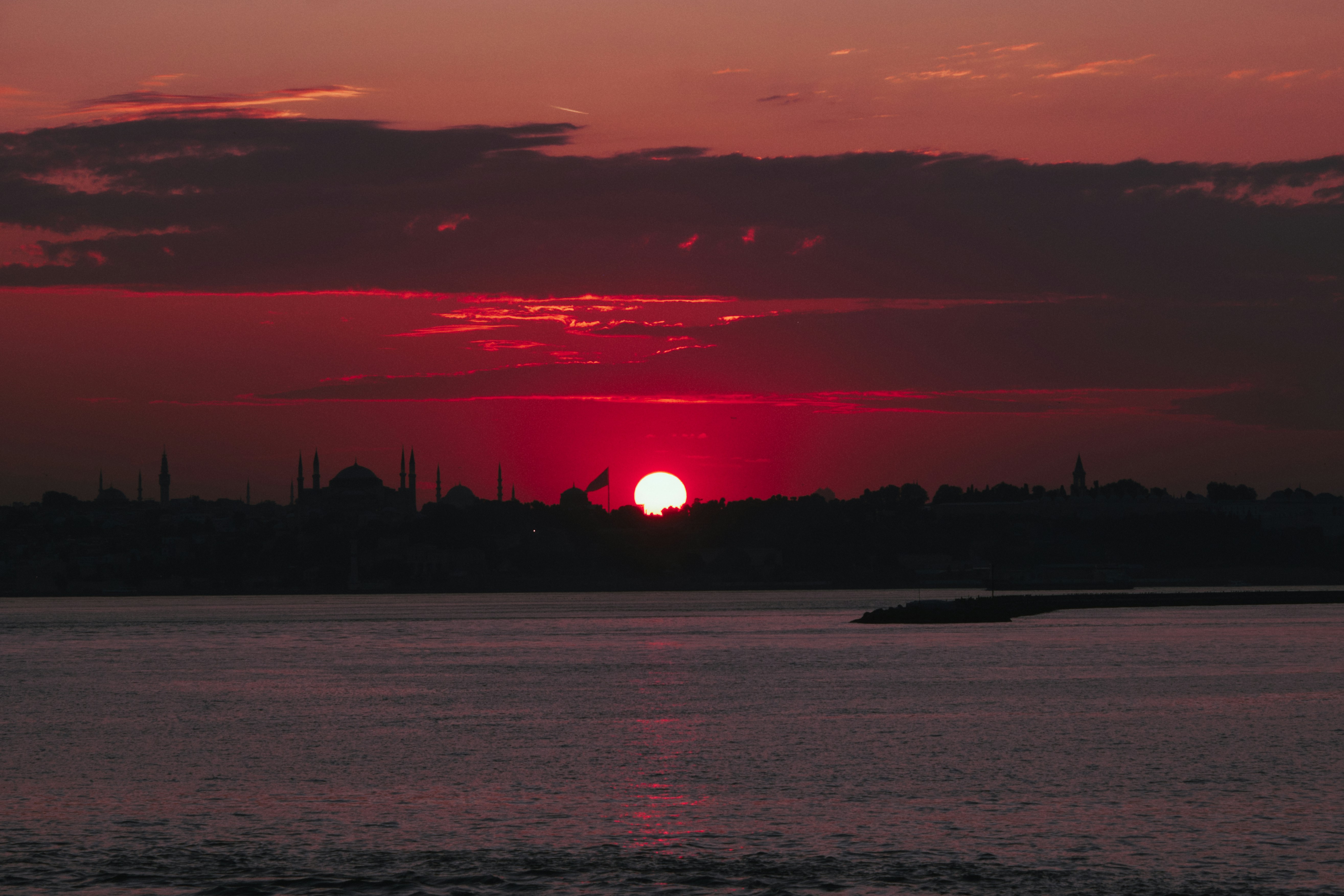 The sun is setting over a large body of water photo – Free Sun Image on ...