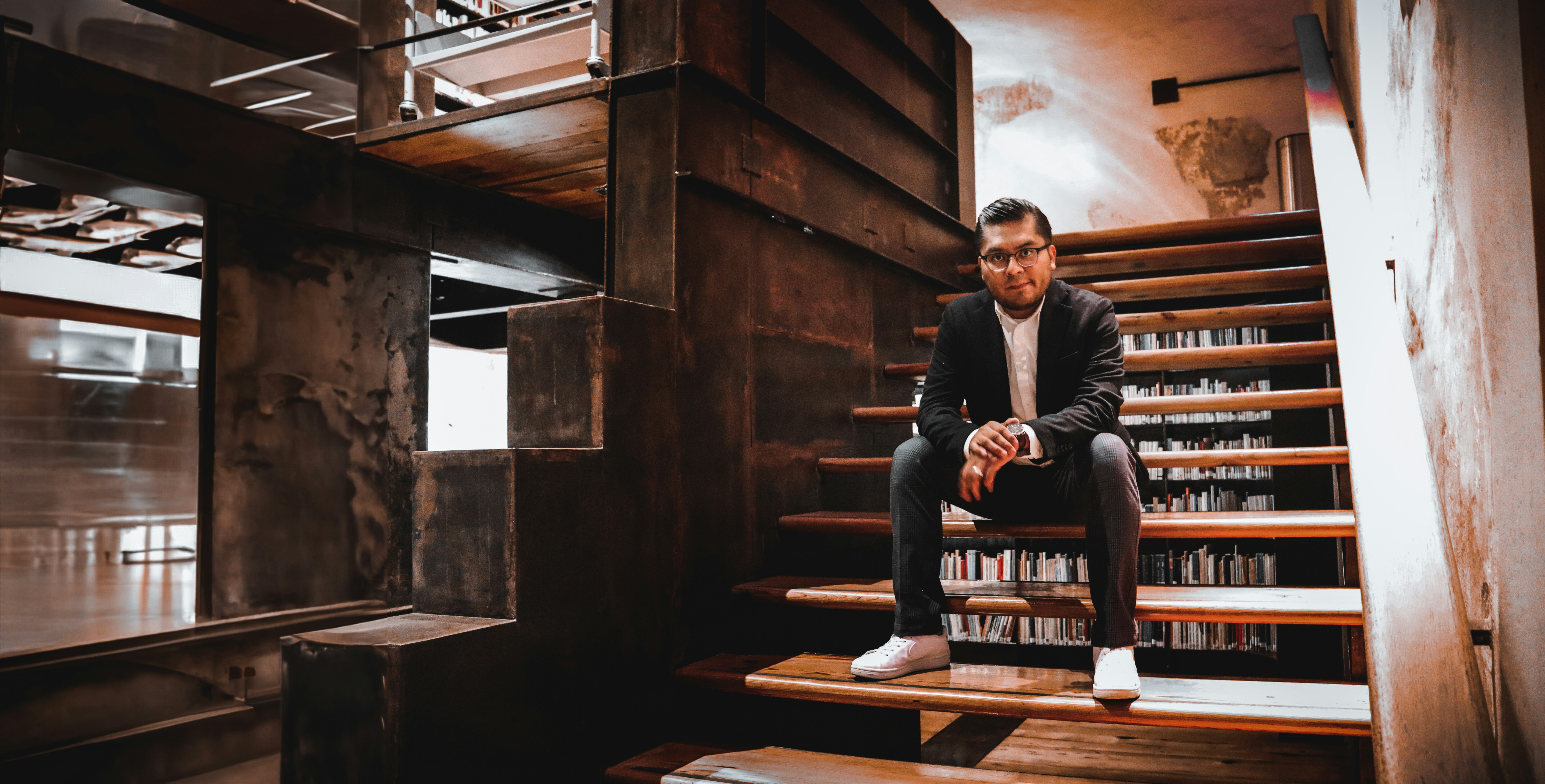 A man in a suit sitting on a set of stairs photo – Free Man Image on ...
