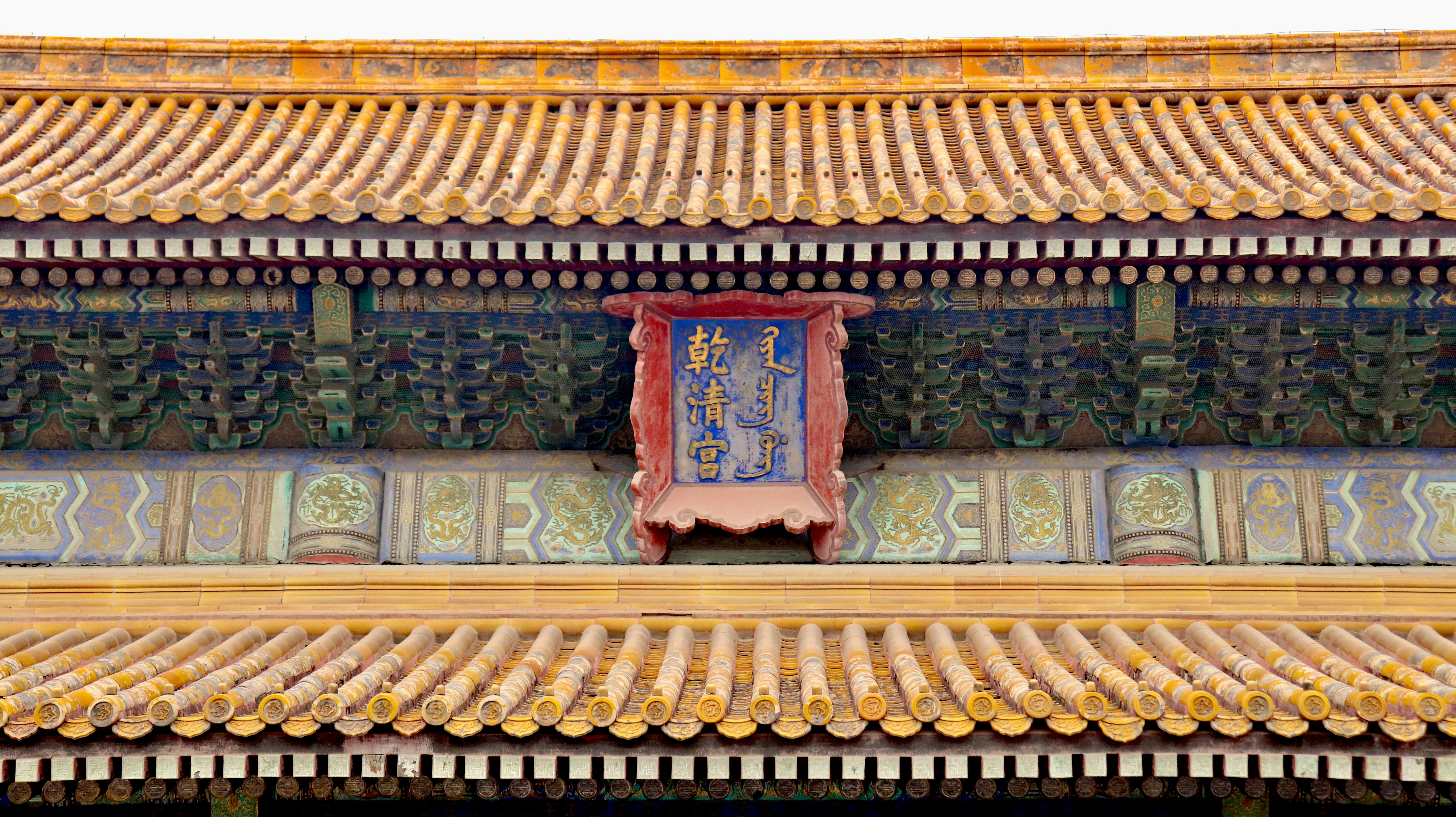 Blue Emblem Centerstage: A Central Plaque on a Golden-Tiled Roof