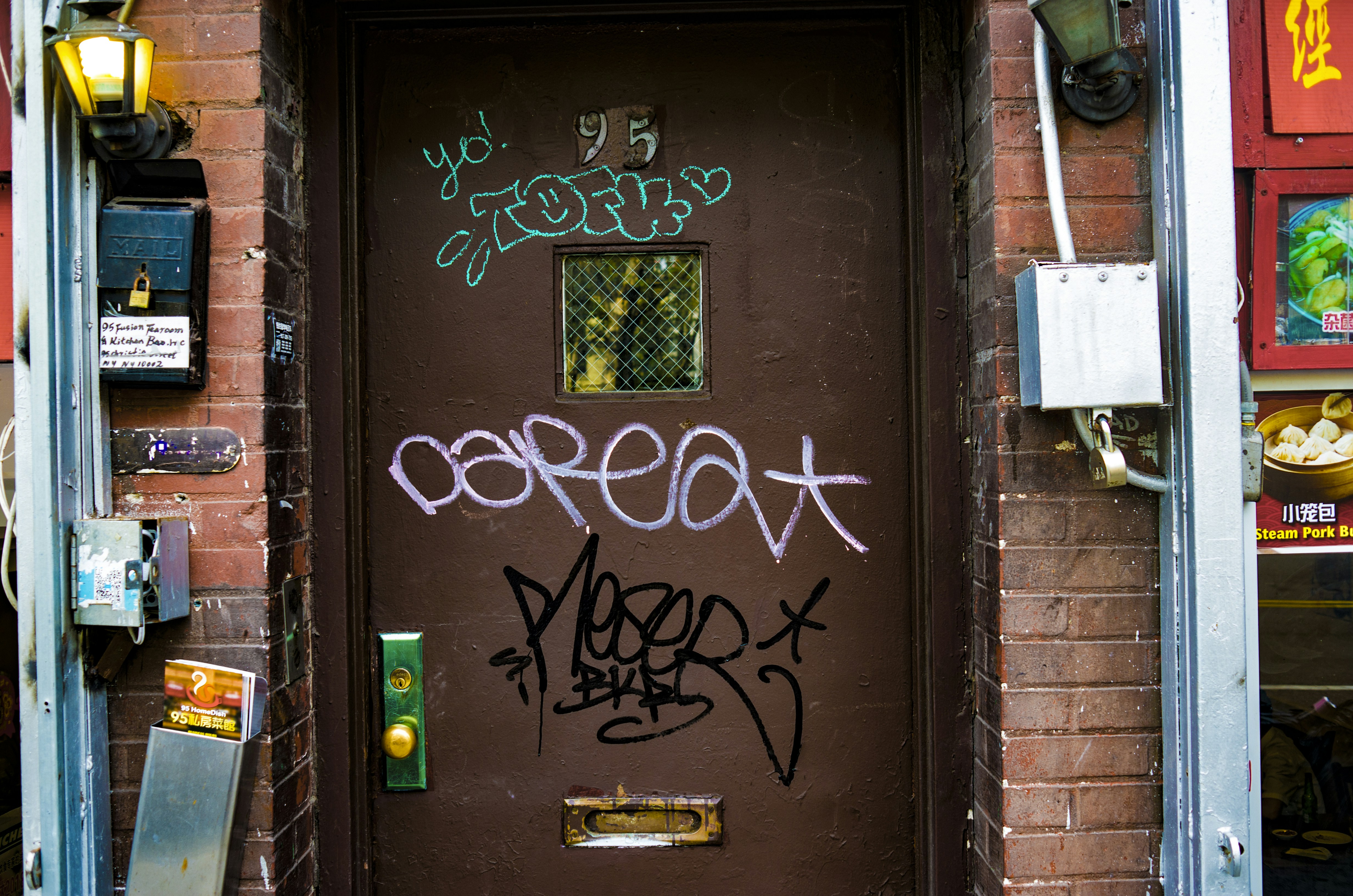 Graffiti Gate in a Brick Alley: Neon Tags on a Weathered Door