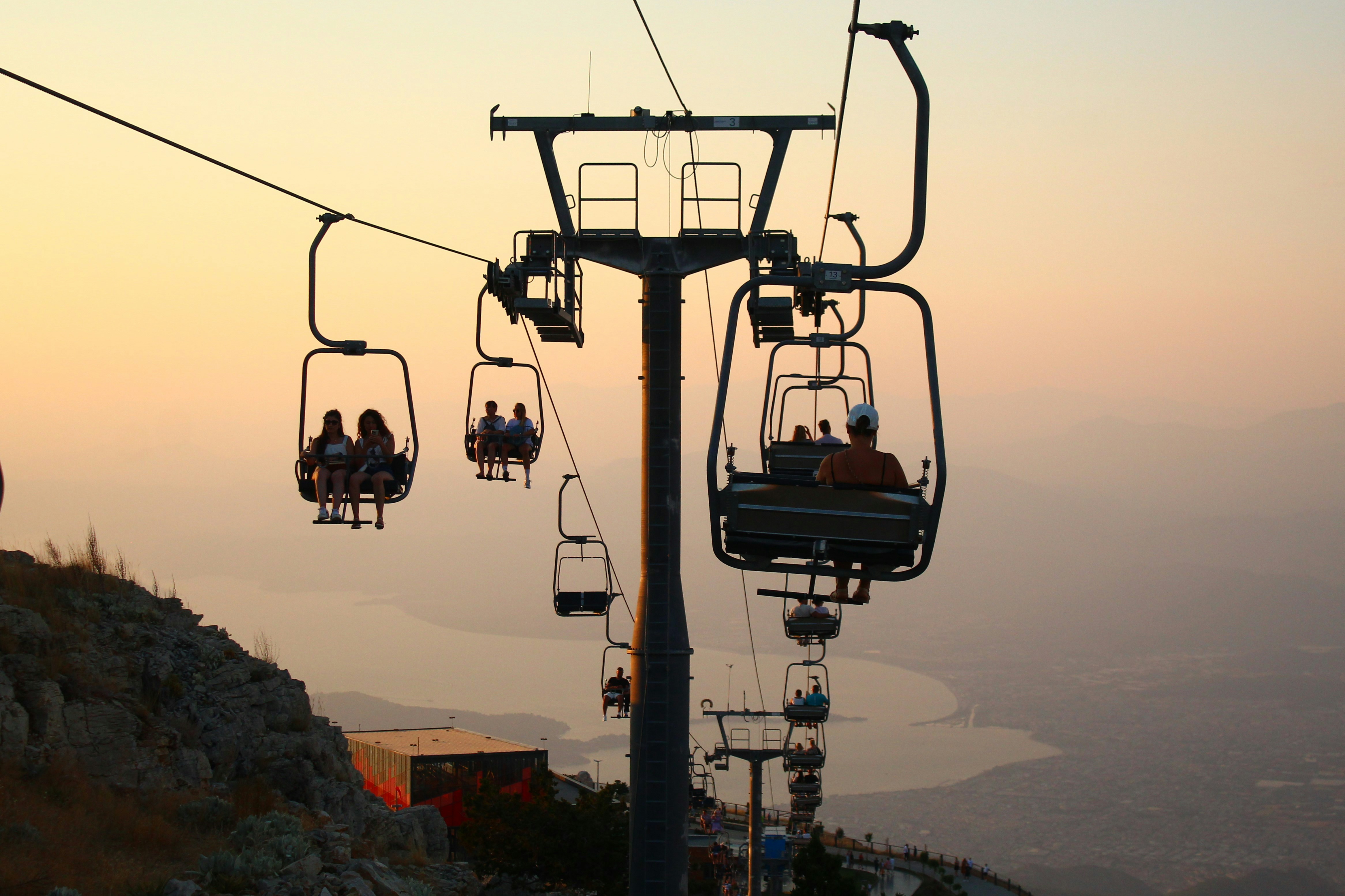 Silhouetted Ascent: Sunset Chairlifts Tracing a Quiet Coastal Horizon
