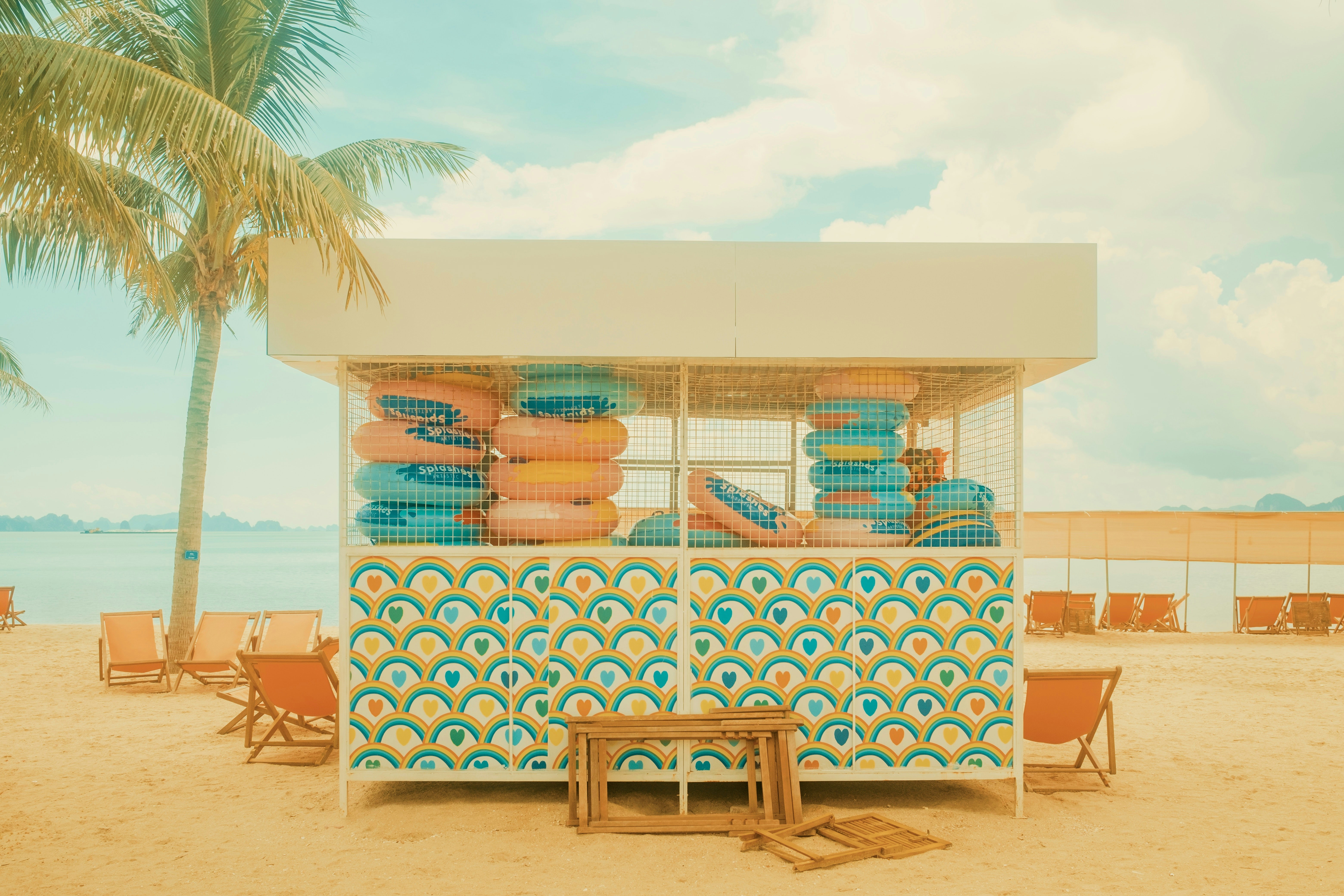 Un petit stand sur une plage avec des chaises et une table photo ...