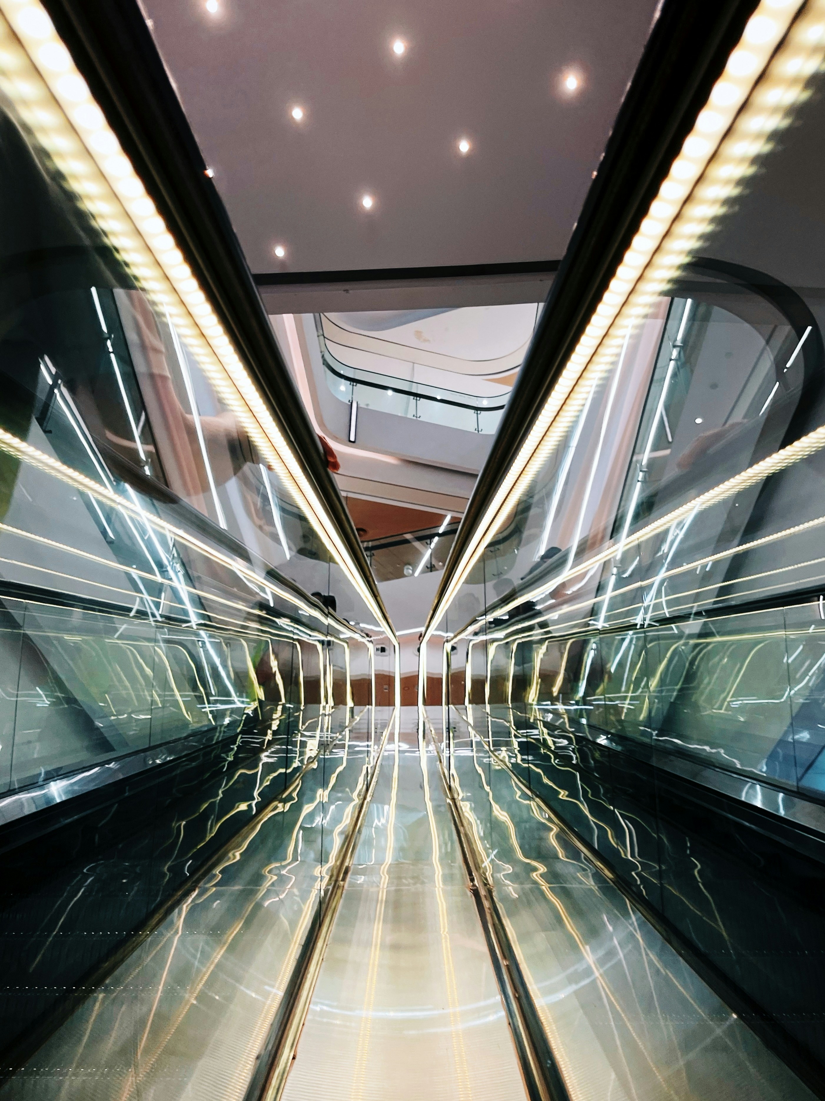 A moving escalator in a building with lights photo – Free Wallpaper ...