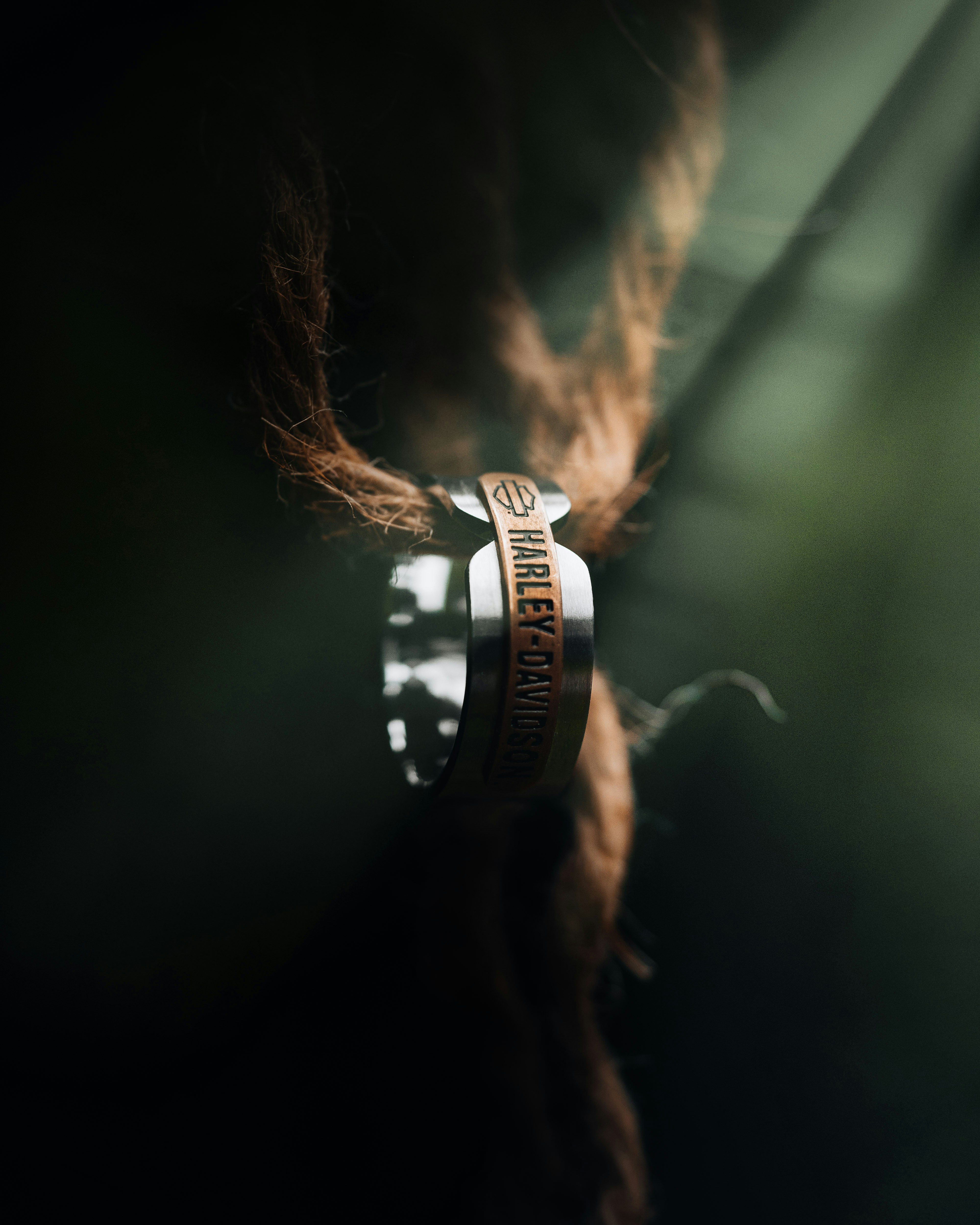 Metal RING of Power: Close-up of a Harley-Davidson Band Ring on a Coiled Leather Strap