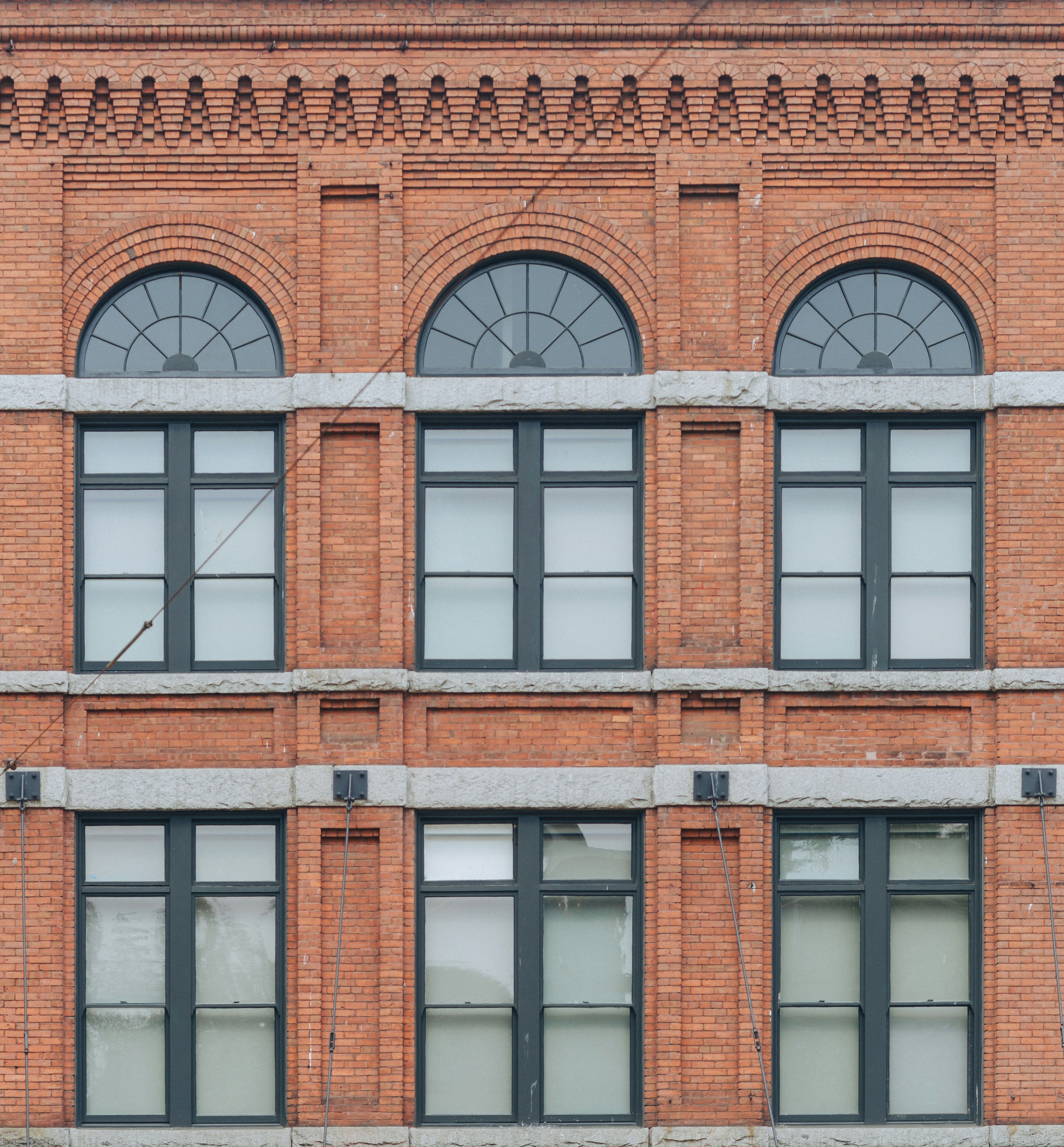 A red brick building with arched windows and a clock photo – Free Bc ...