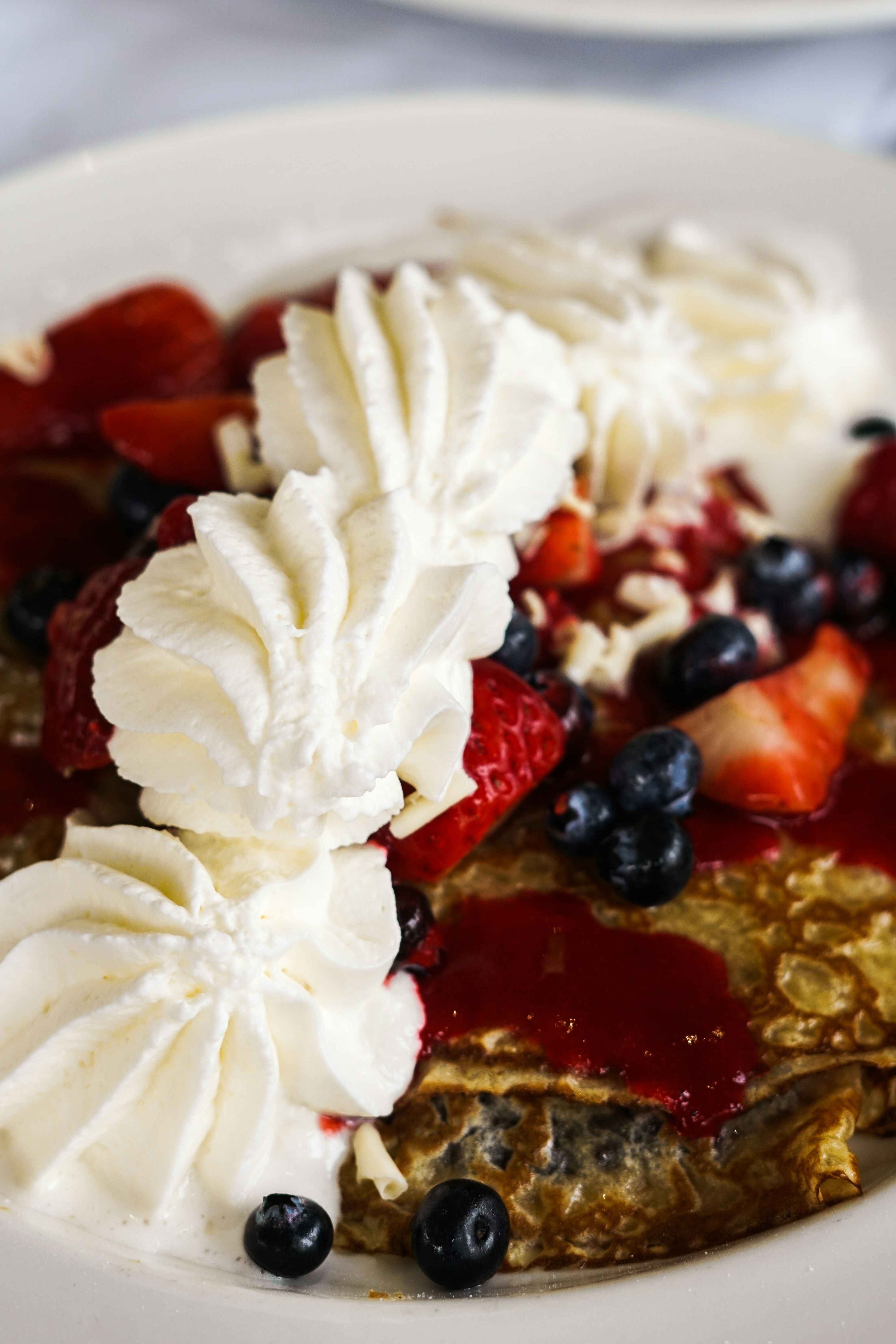 Whipped Cream Crescents Over Berry-Tlecked Dessert Slice