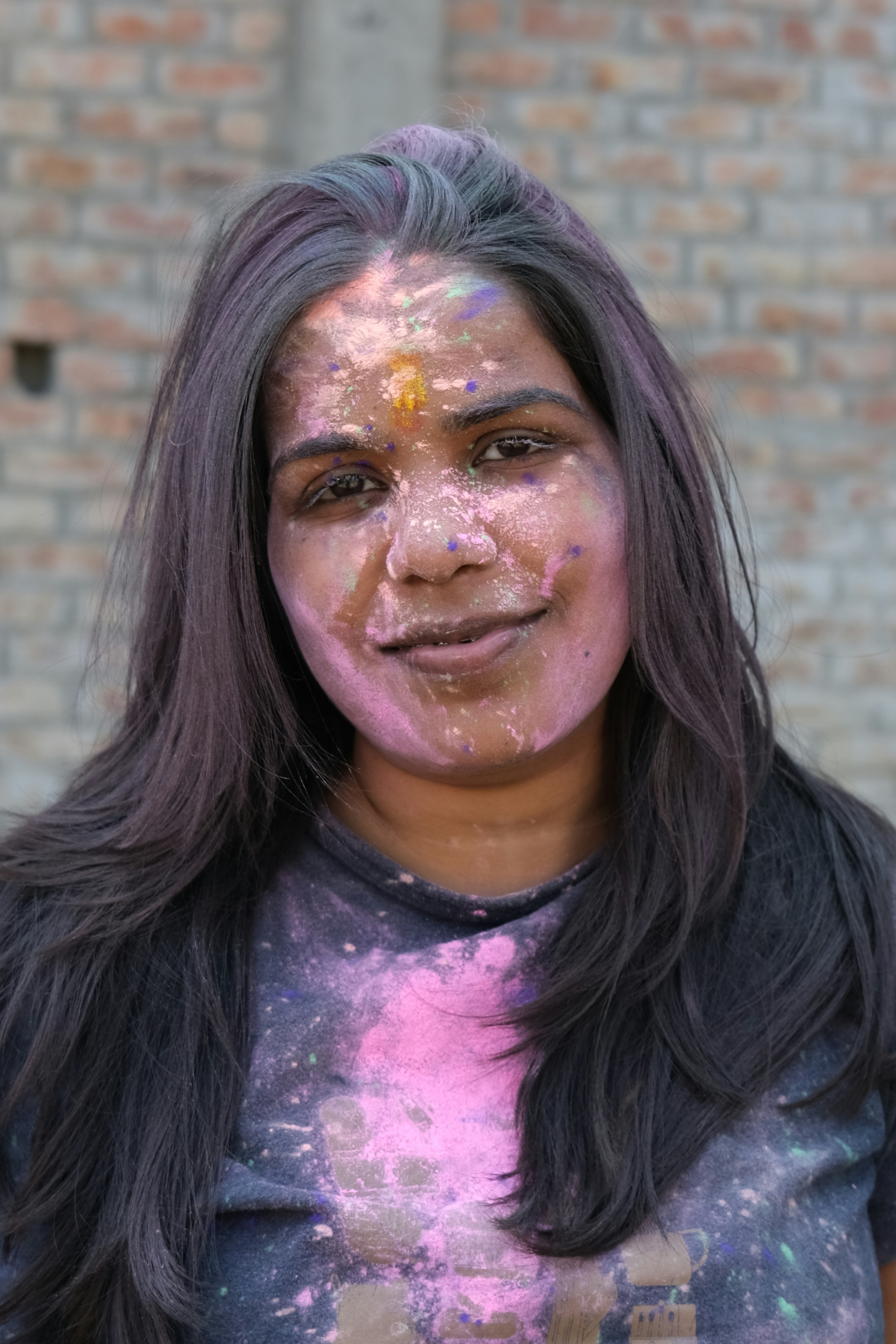 Color-Splashed Portrait: Soft Smile Under a Brick Backdrop