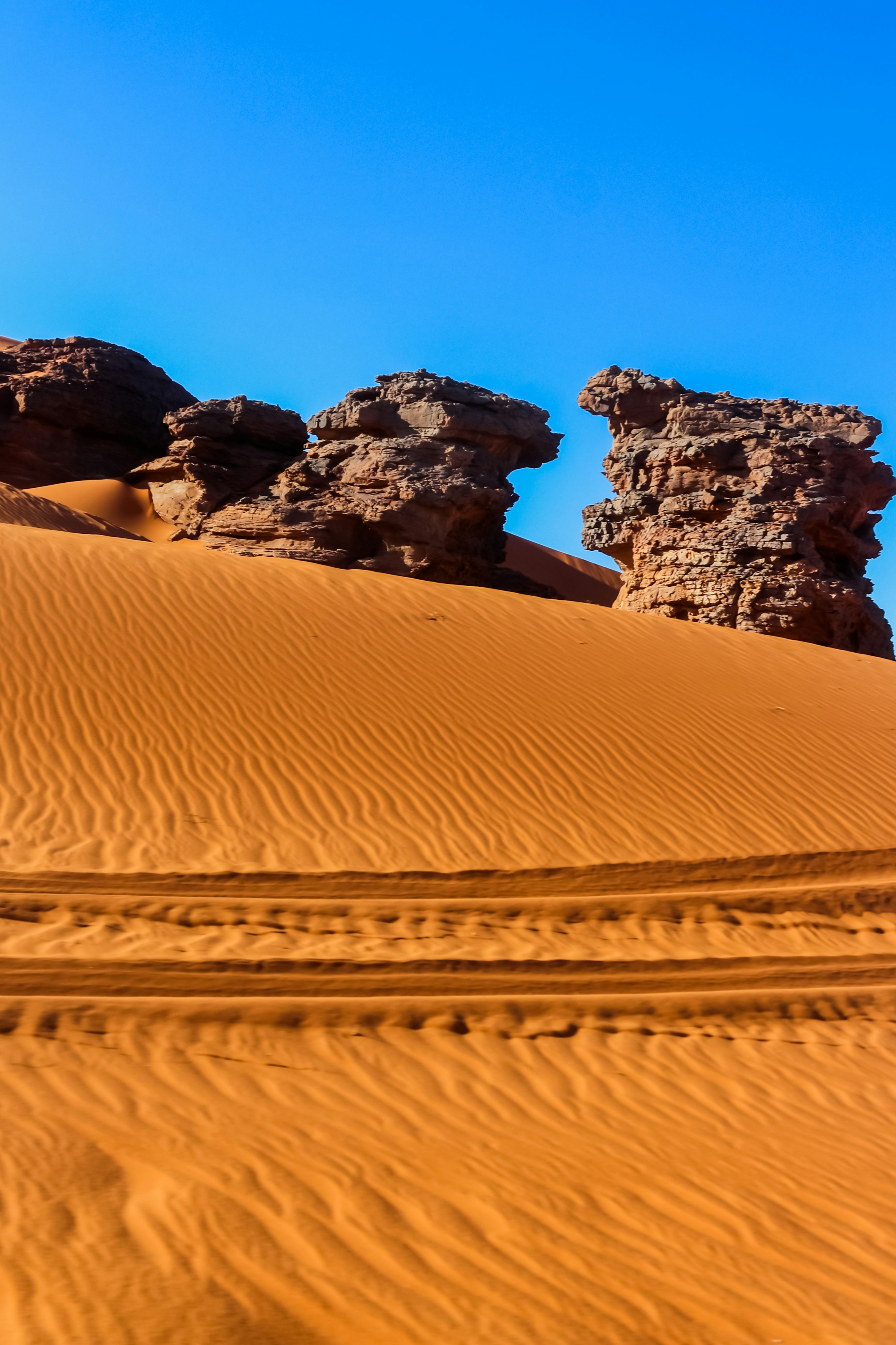 A desert landscape with rocks and sand photo – Free Tadrart rouge Image ...