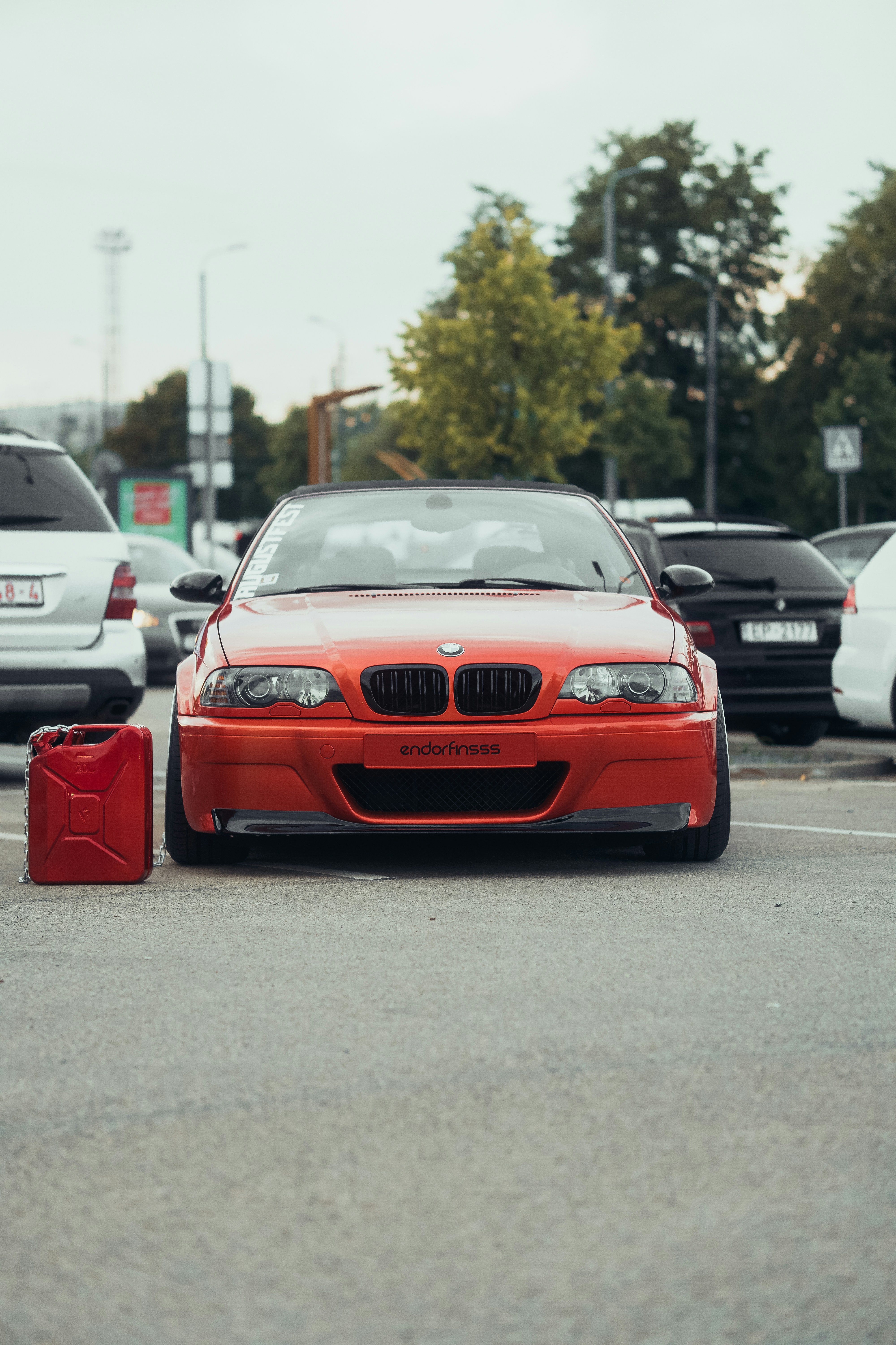 A red car parked in a parking lot next to other cars photo – Free Riga ...