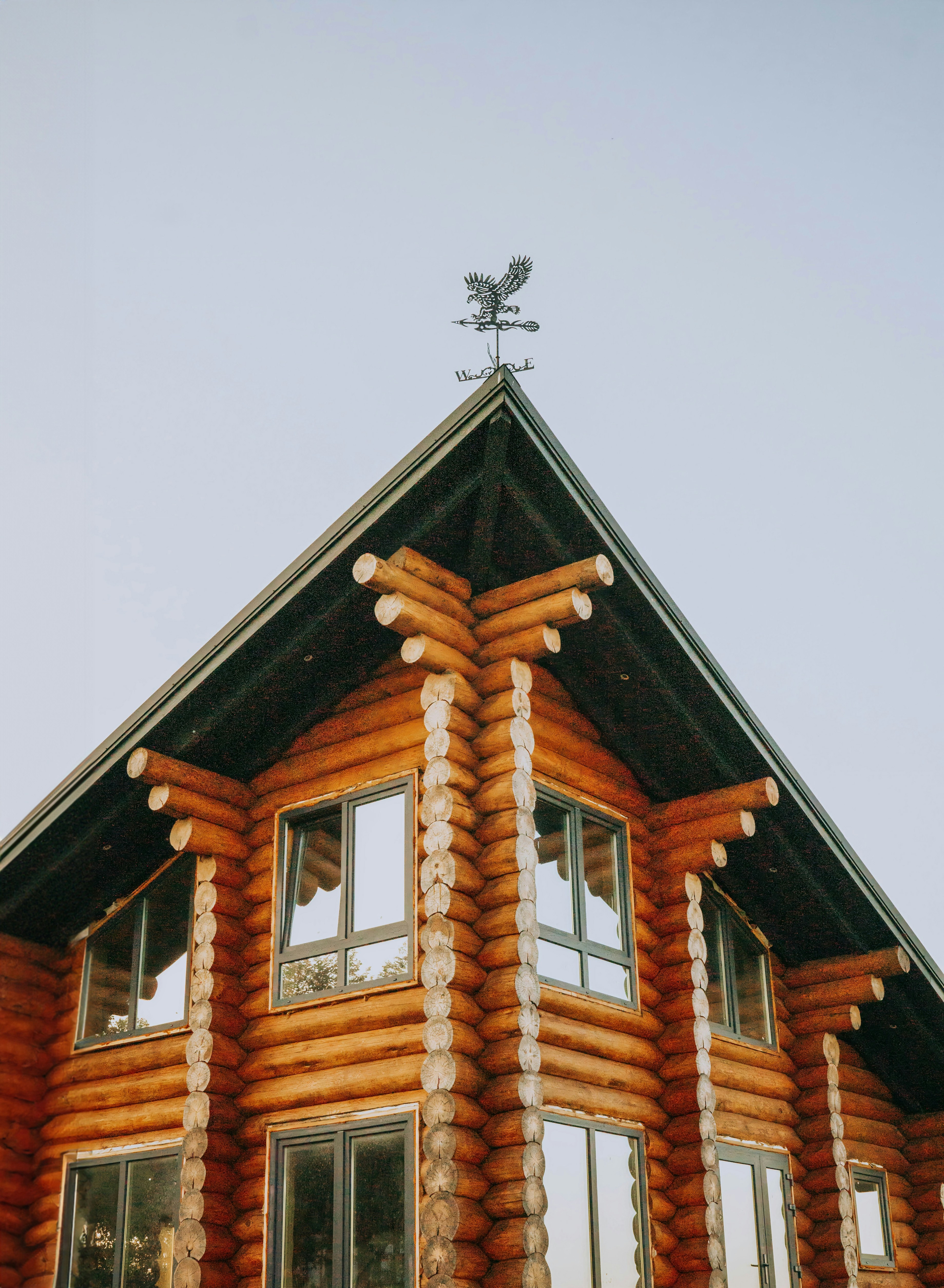 A log house with a weather vane on top of it photo – Free Belarus Image ...