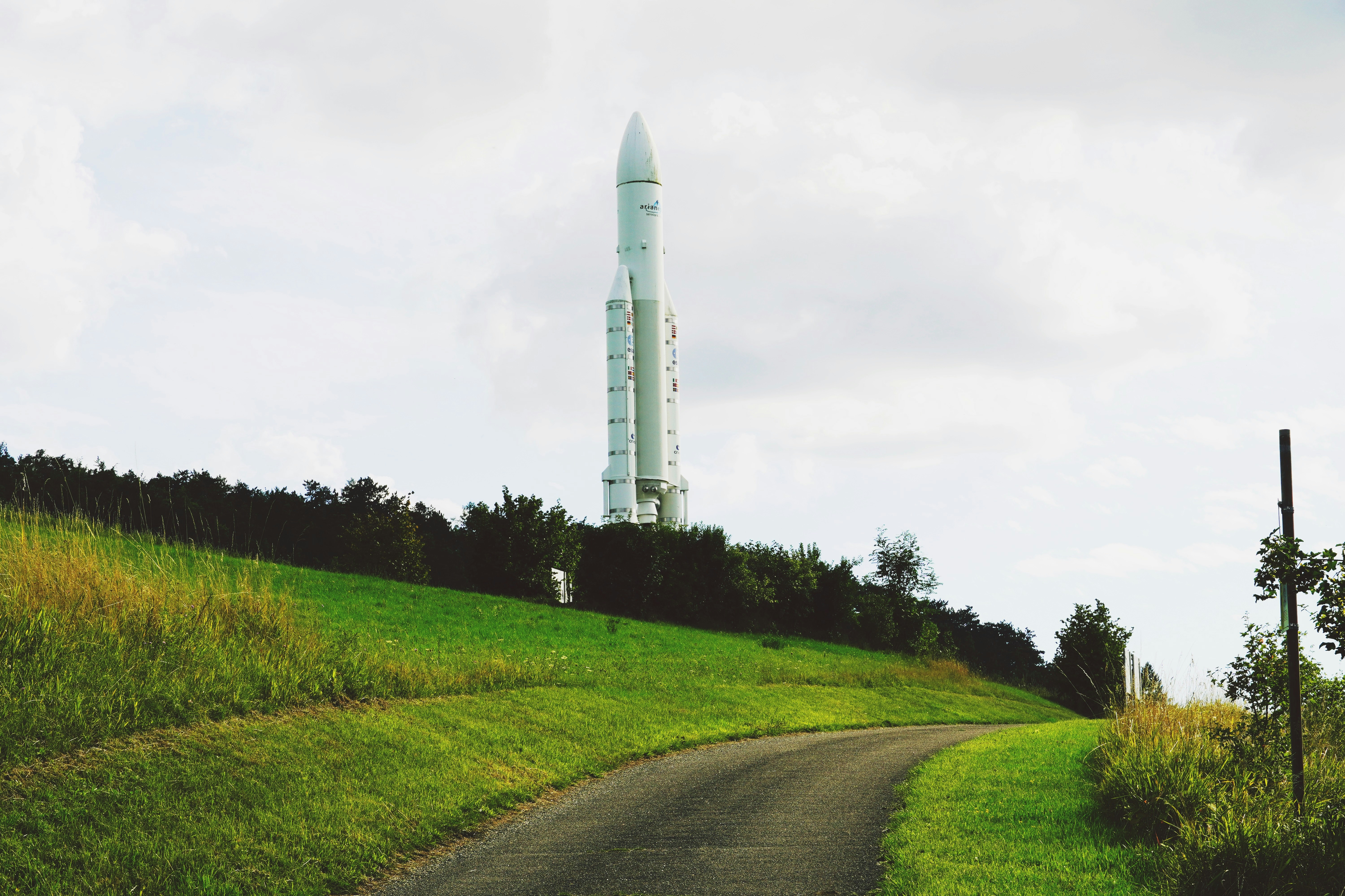 A rocket sitting on top of a green hill photo – Free Rakete Image on ...