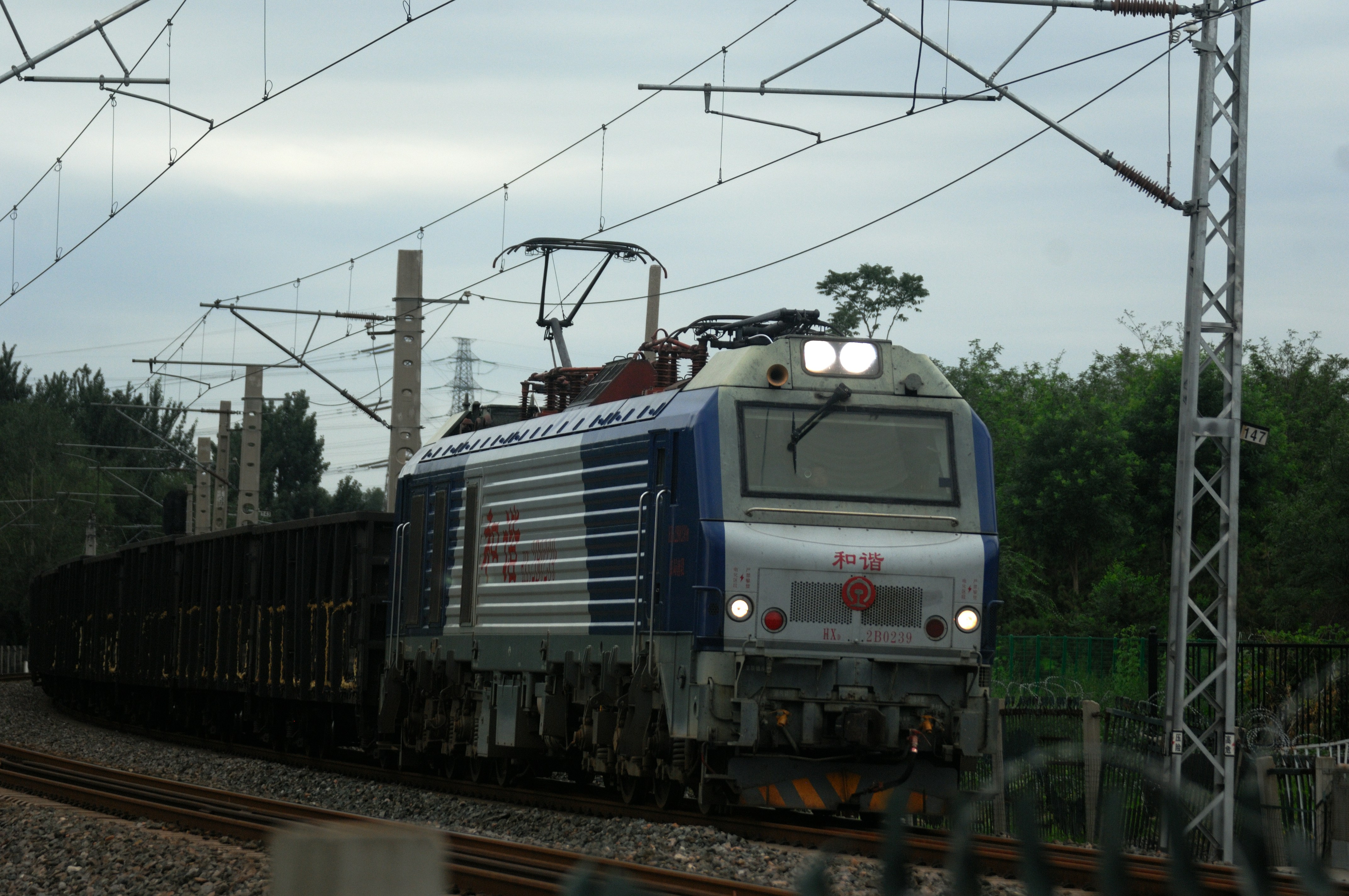 A blue and silver train traveling down train tracks photo – Free China ...