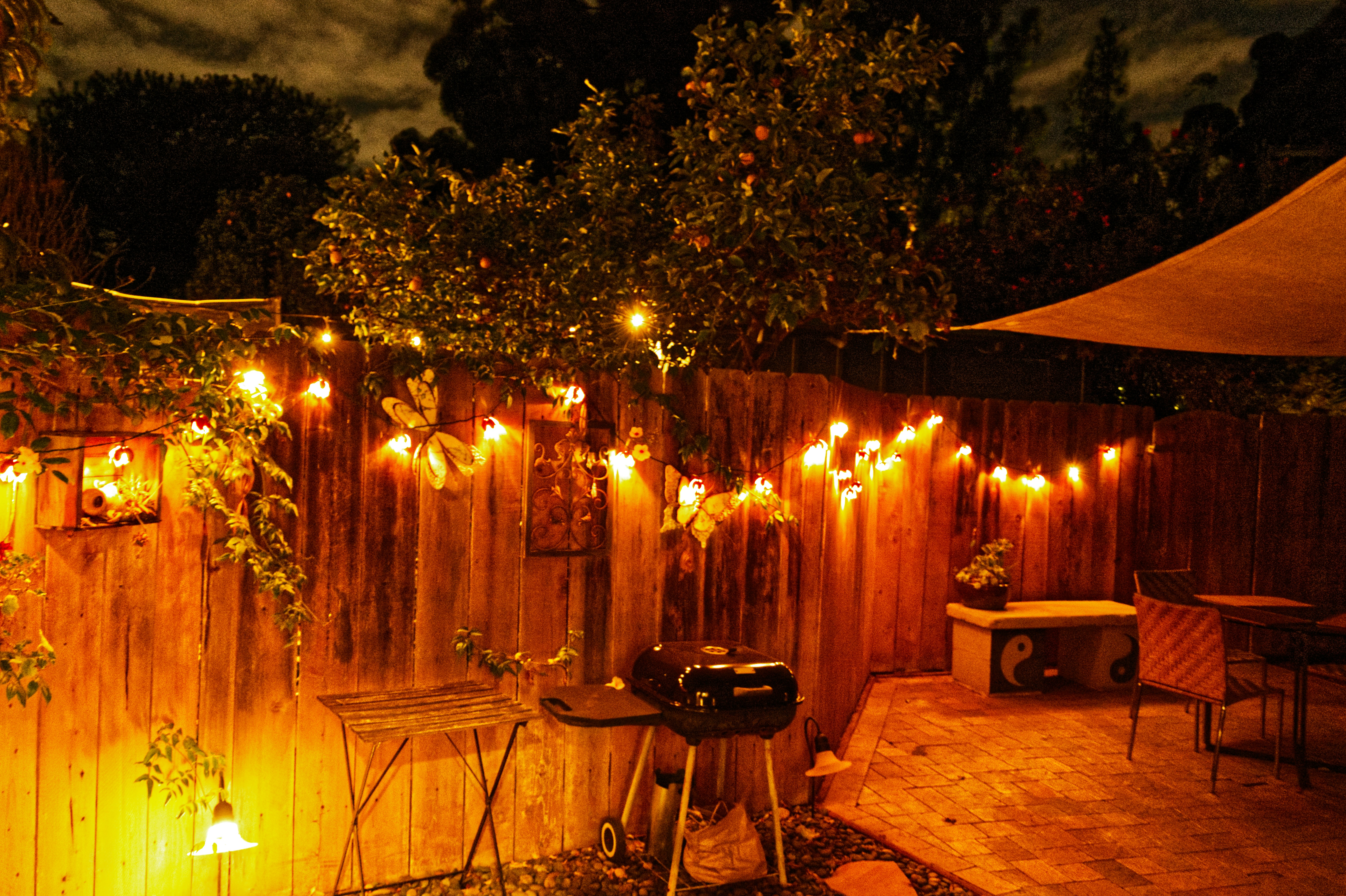 Glow Beneath the Fence: A Nighttime Backyard Barbecue Scene
