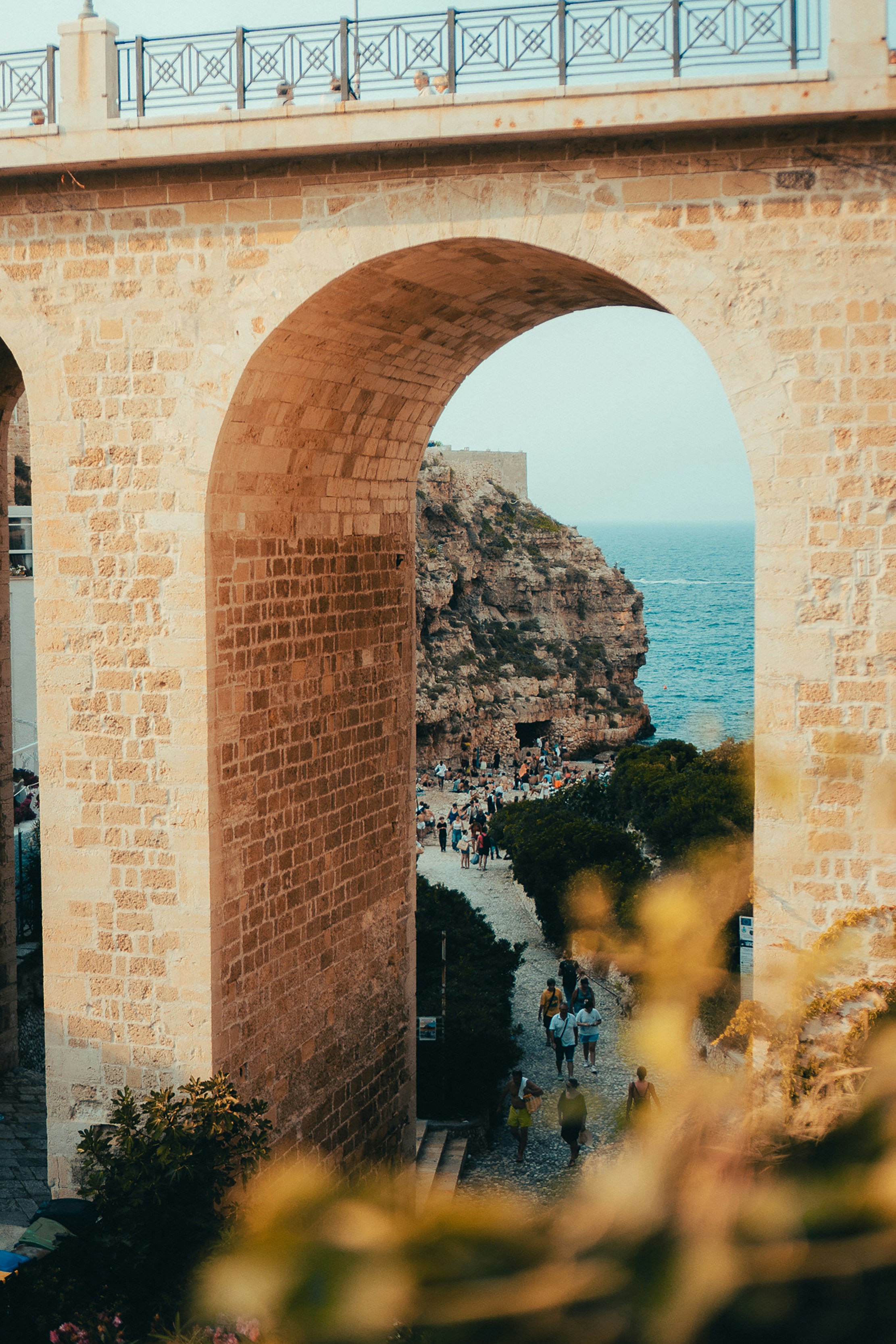 A stone arch over looking a body of water photo – Free Background Image ...