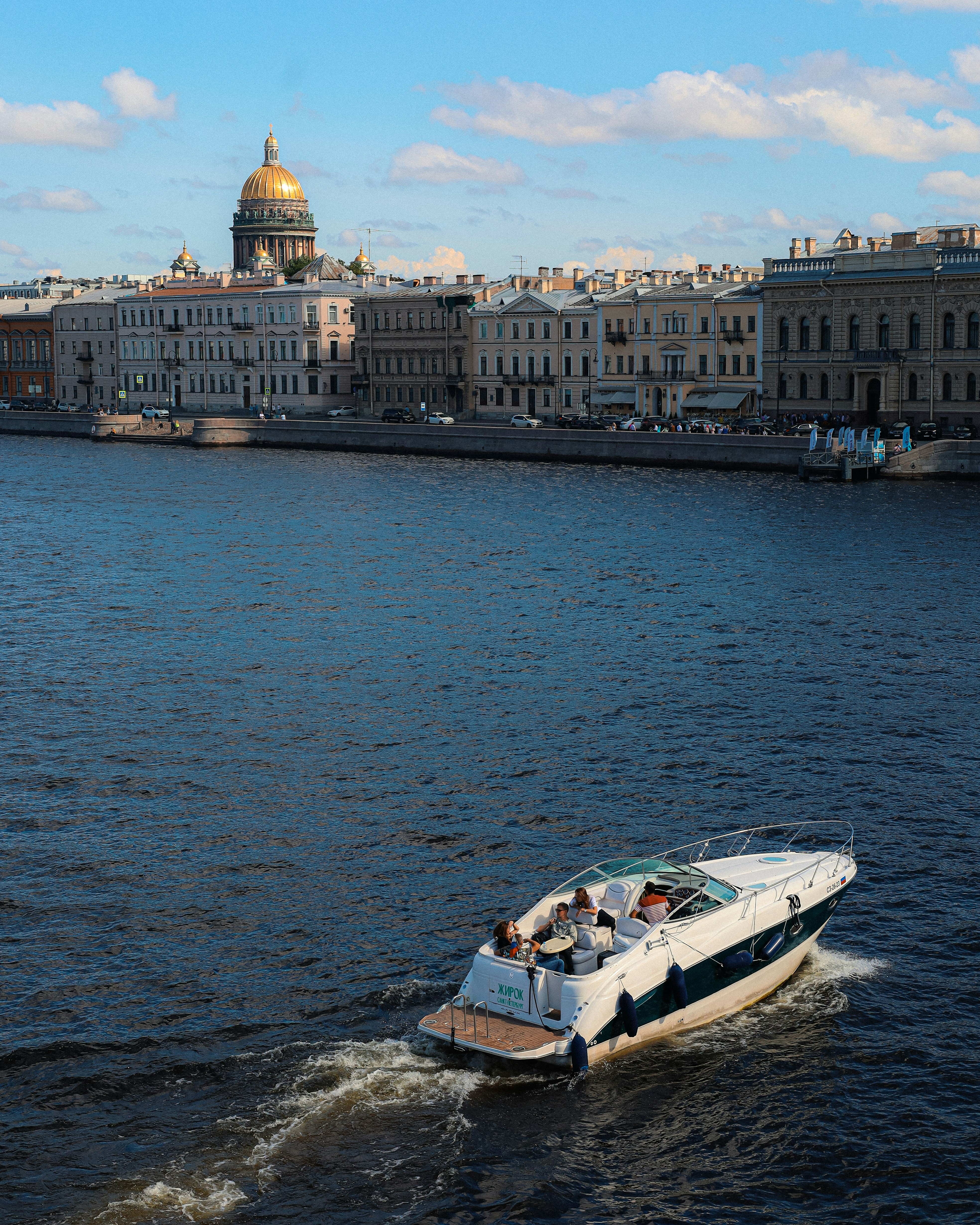 Cityfront by Water: A White Motor Yacht Glides Past Historic Banks