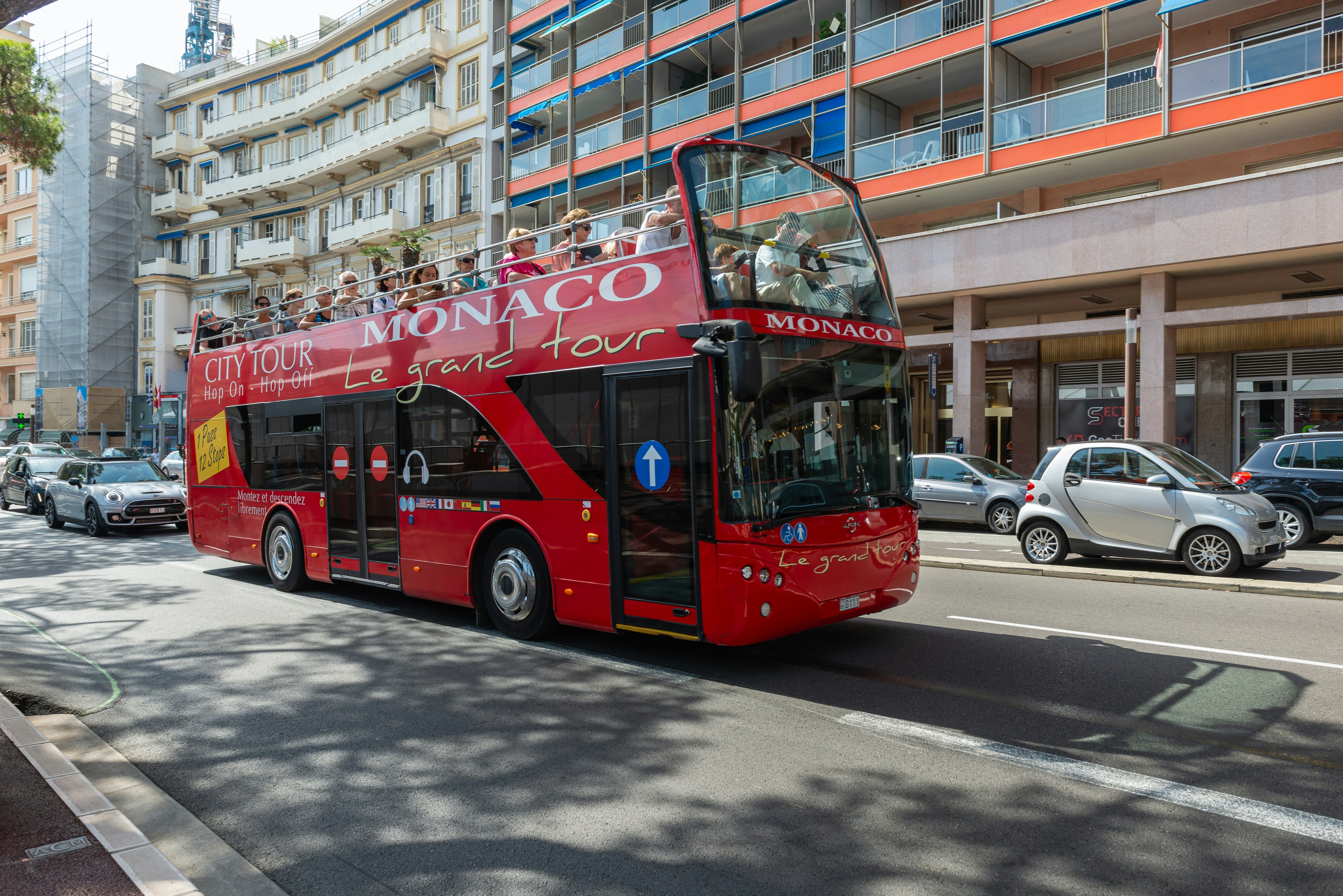 A red double decker bus driving down a street photo – Free Car Image on ...