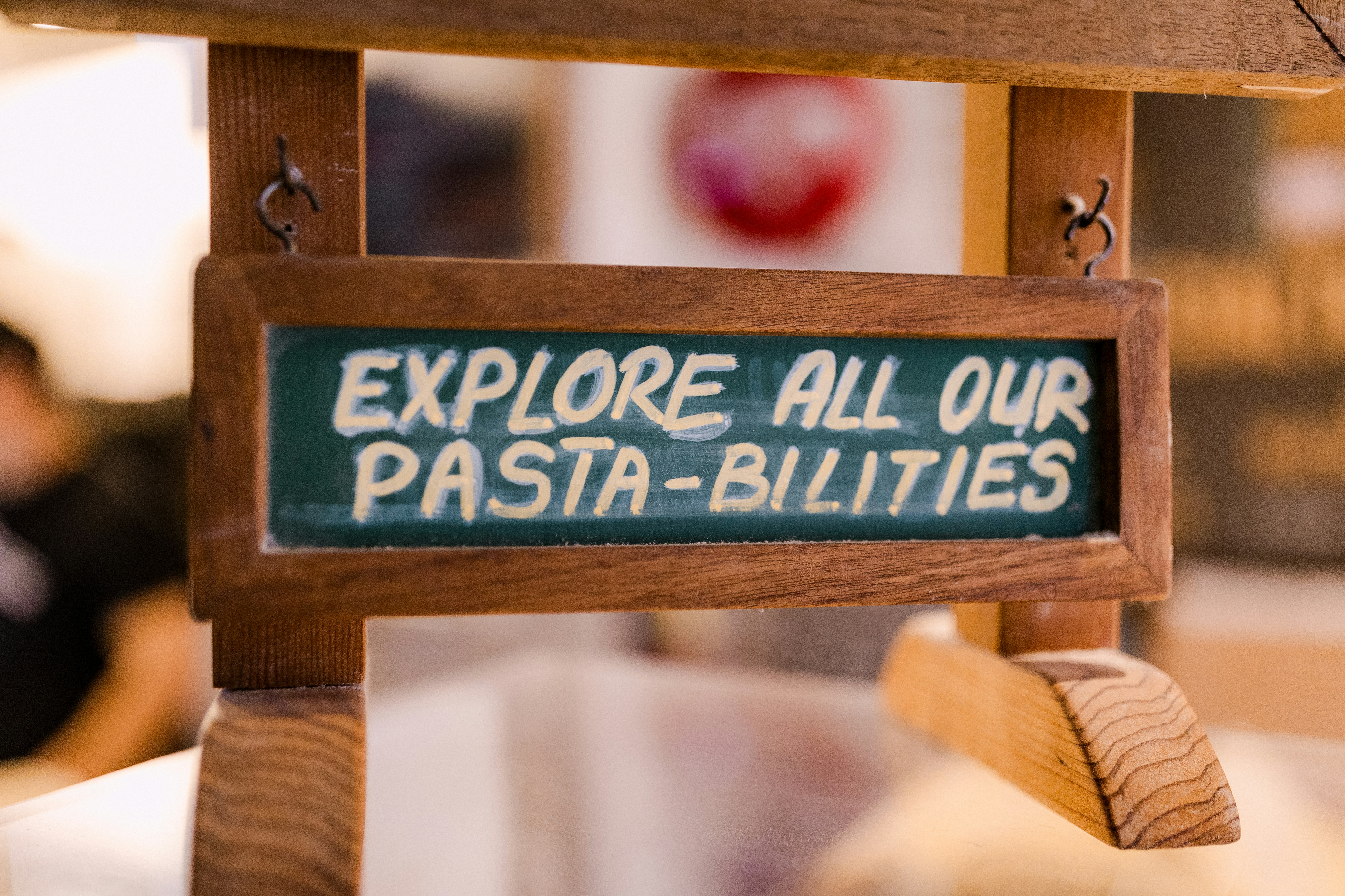 A sign that says explore all our pasta - bites photo – Free Wood Image ...