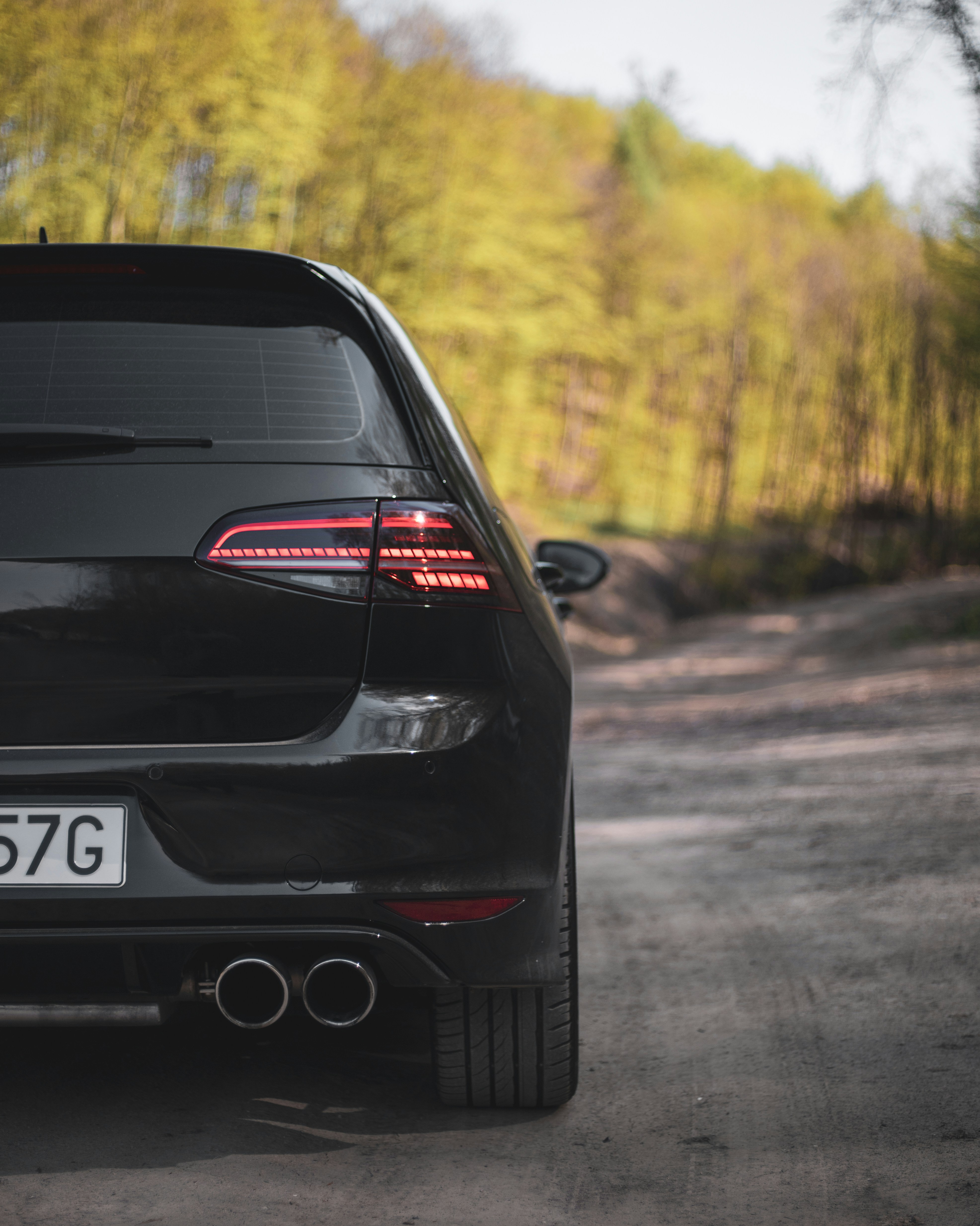 The back end of a black car parked in a parking lot photo – Free Car ...