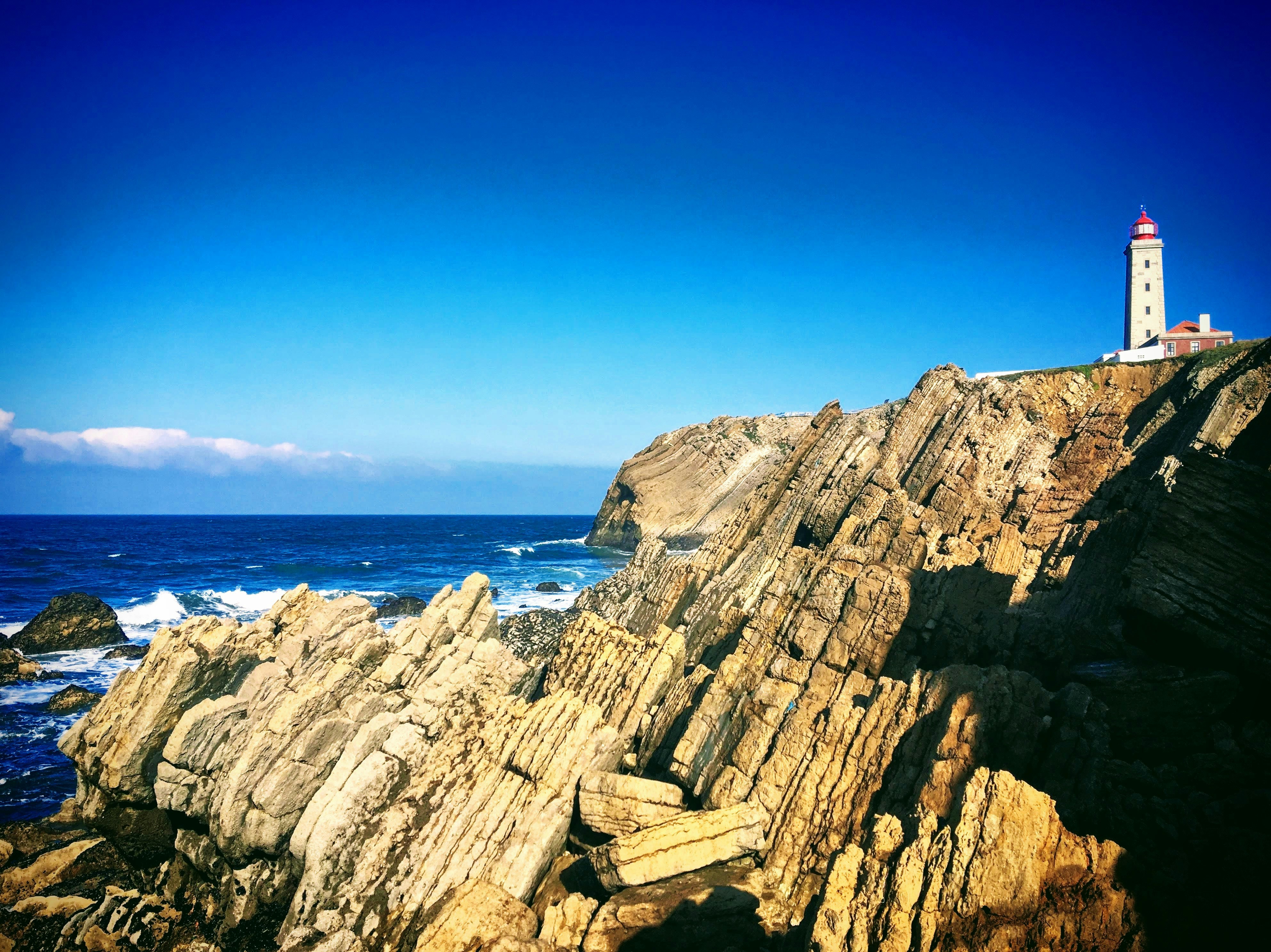 Edge of Light: Lighthouse Standing Guard Over Jagged Cliffs