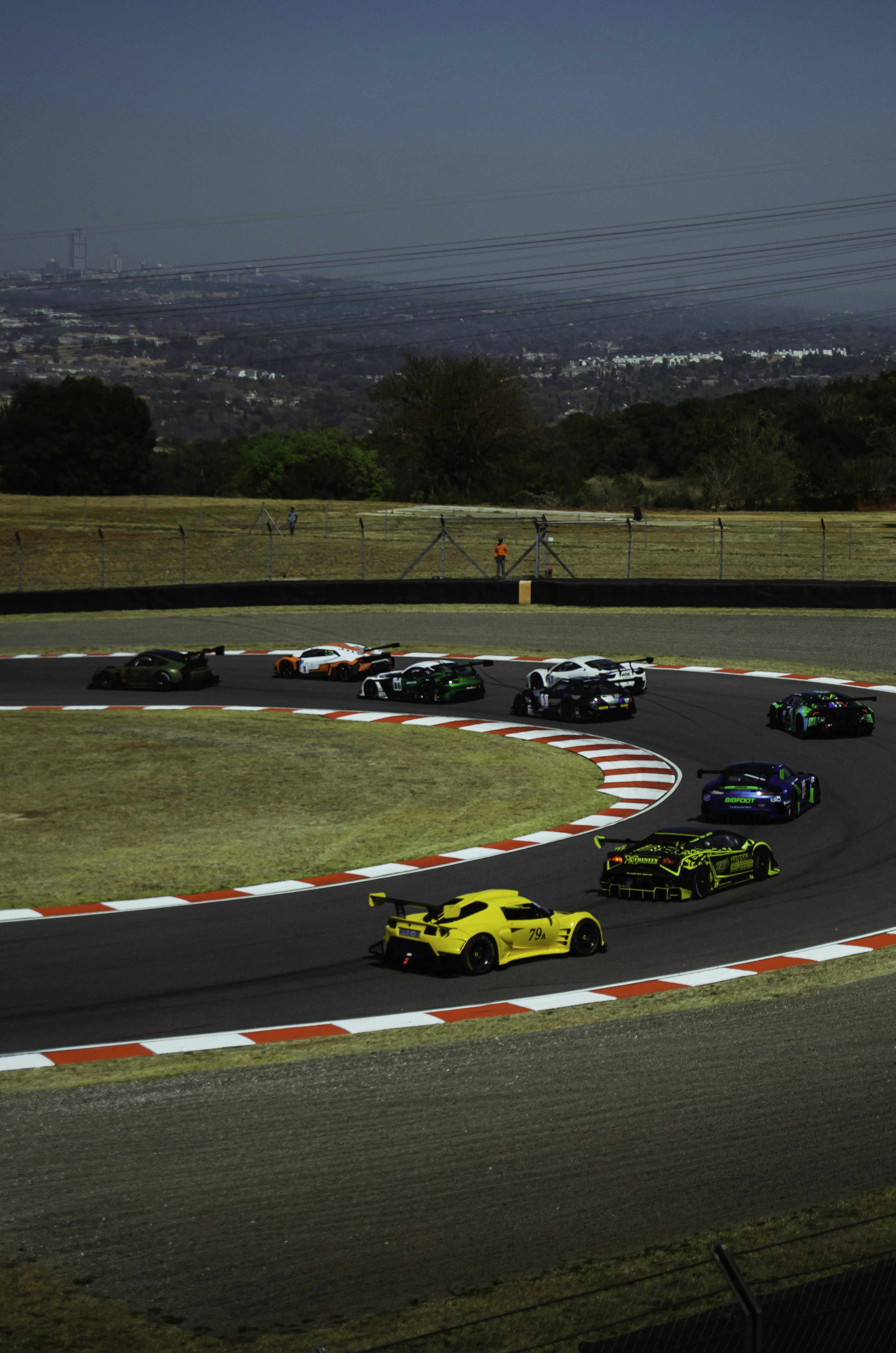 A group of cars driving around a track photo – Free Car Image on Unsplash