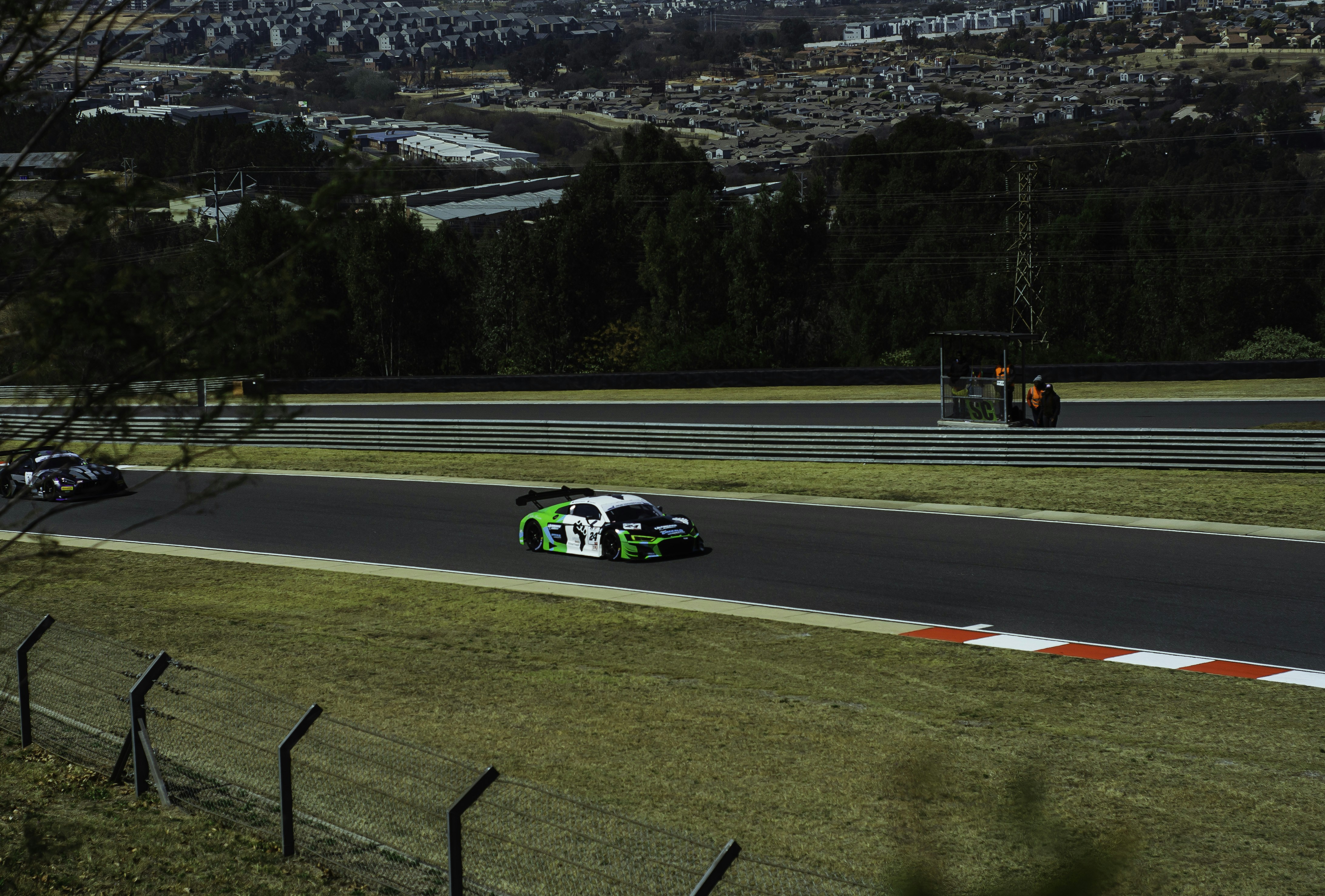 A green race car driving down a race track photo – Free Wallpaper Image ...