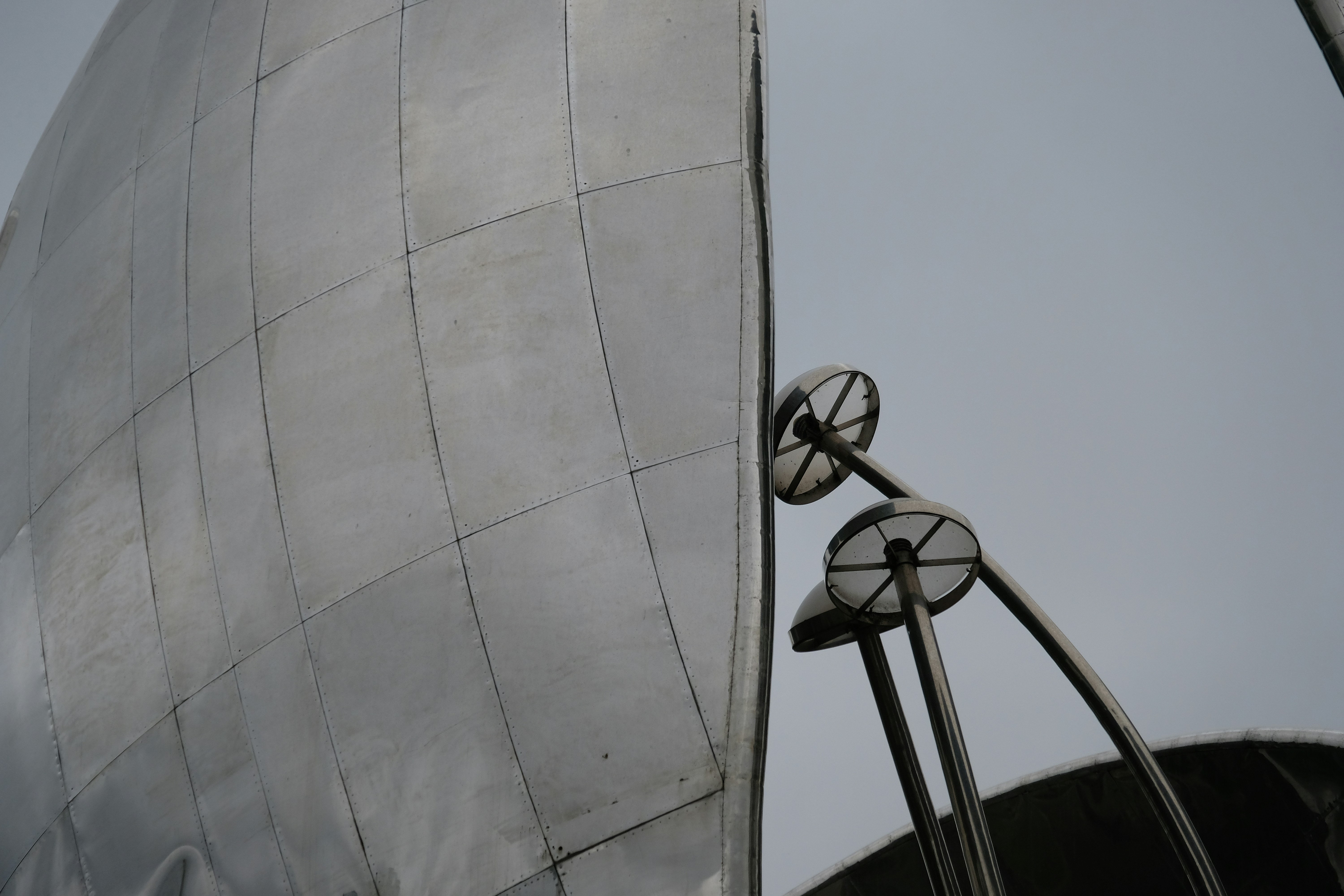 Monolithic Rhythm: Close-Up of a Parabolic Dish and Its Iron Spine