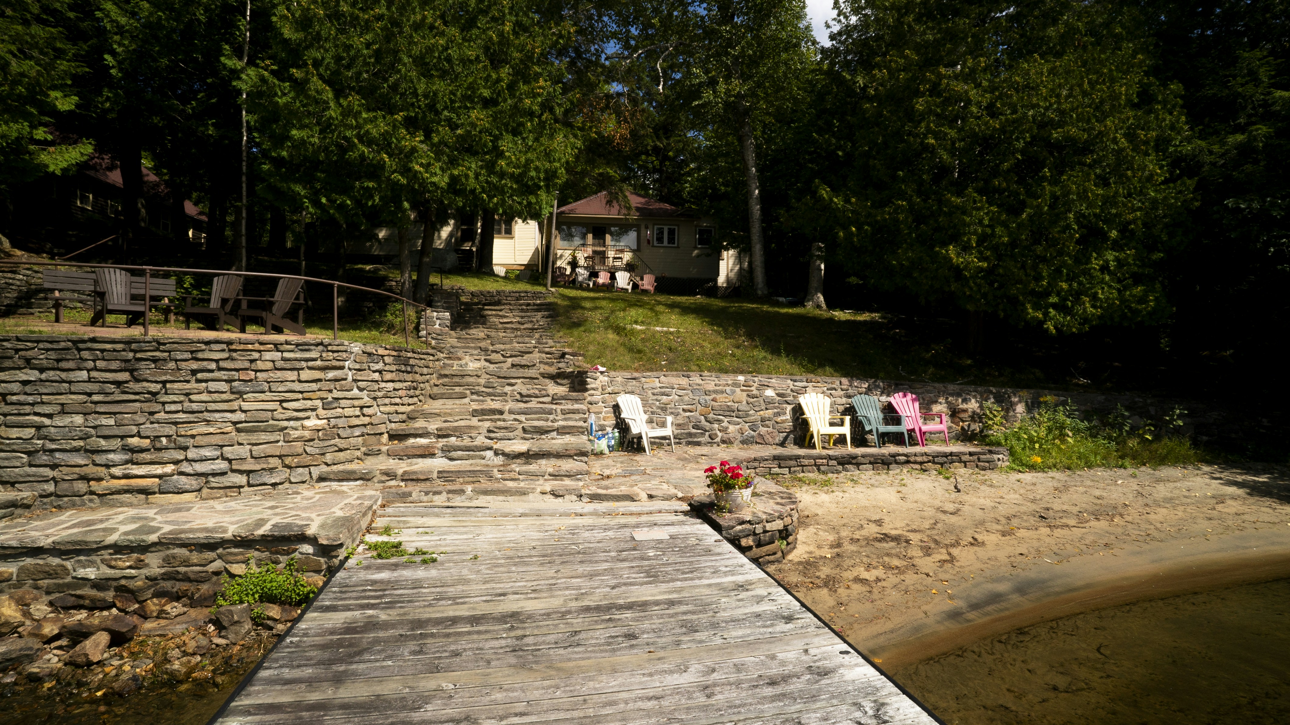Sunlit Riverside Loungers Framed by Stone Steps and a Wooden Dock