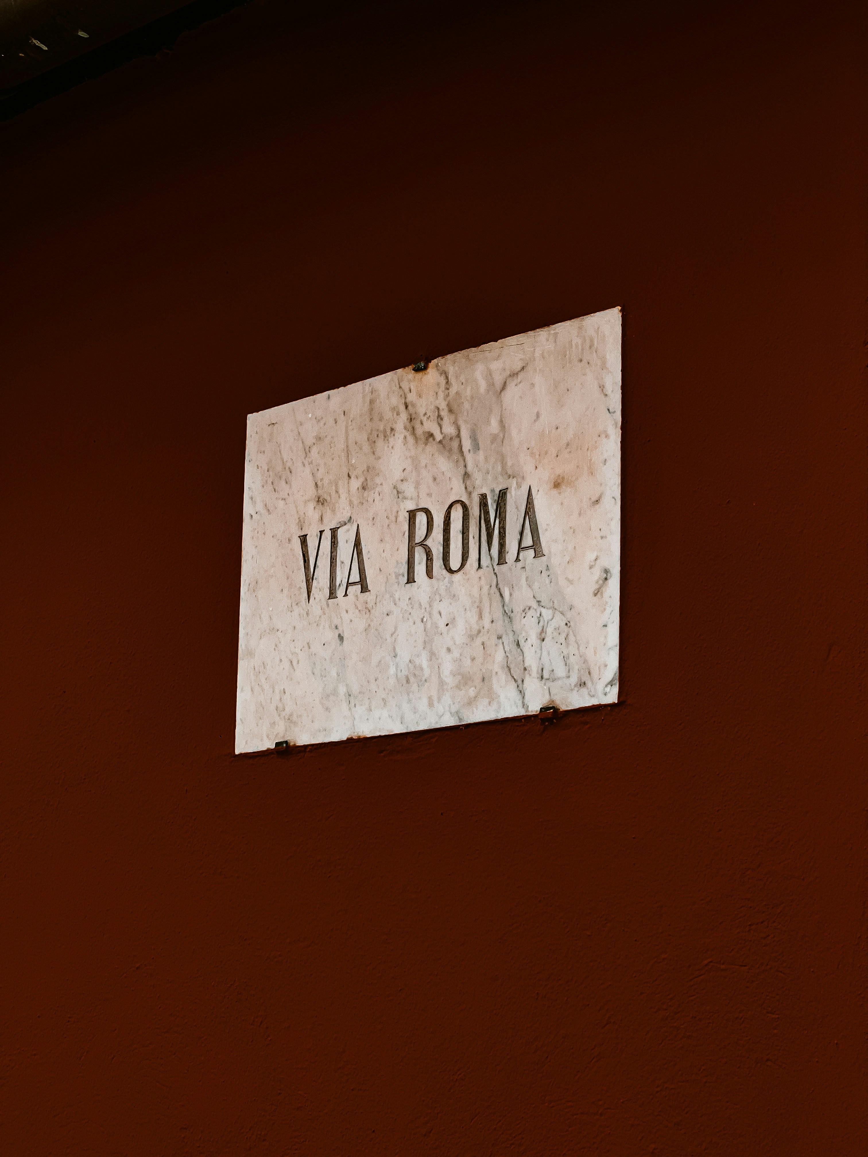 VIA ROMA Marble Plaque on a Warm Terracotta Wall