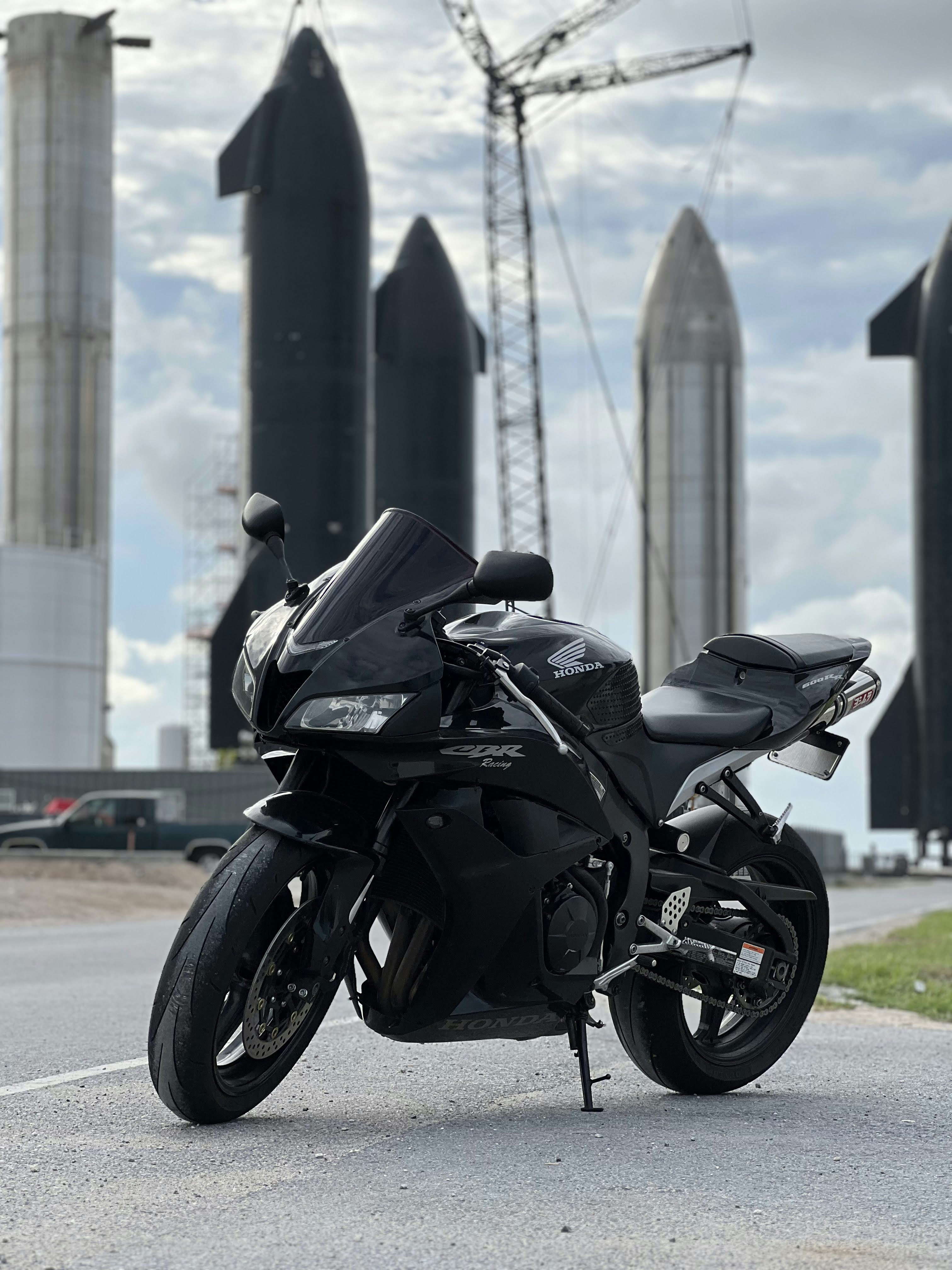 Black sportbike at dusk with rocket towers in the background
