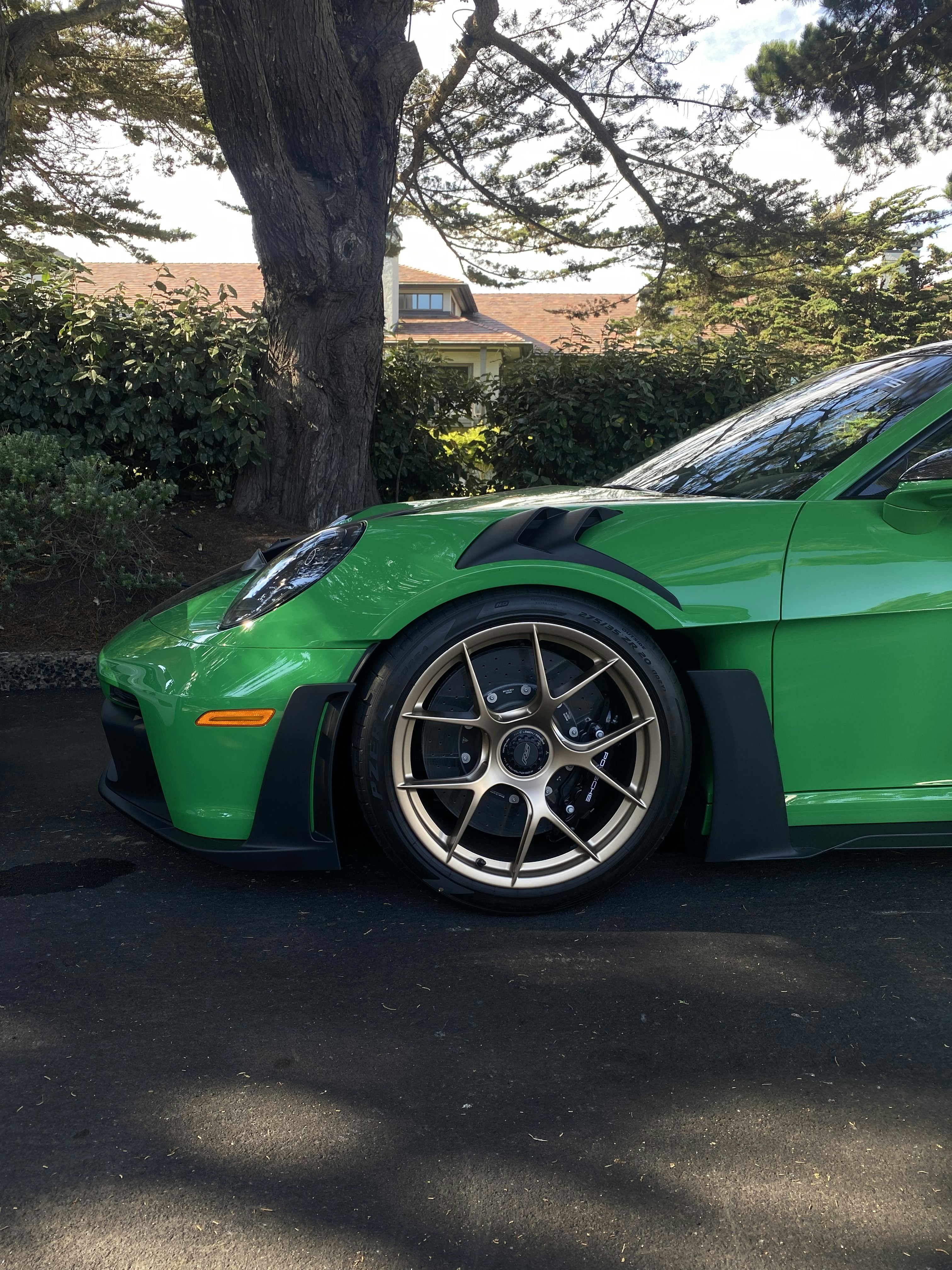 Emerald Velocity: Close-Up on a Parked Green Porsche Wheel