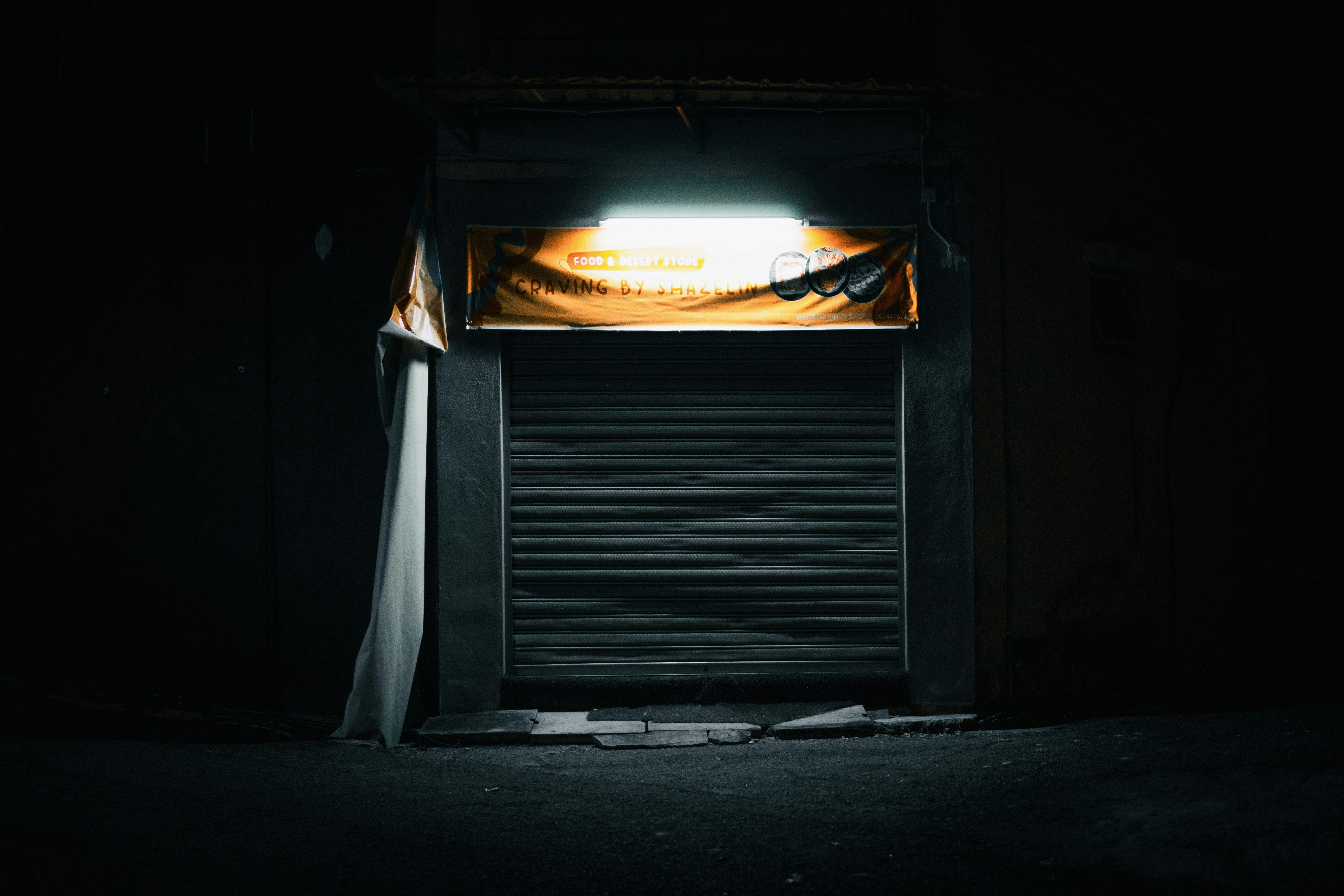 Midnight Facade: An Illuminated Banner Over a Closed Shopfront