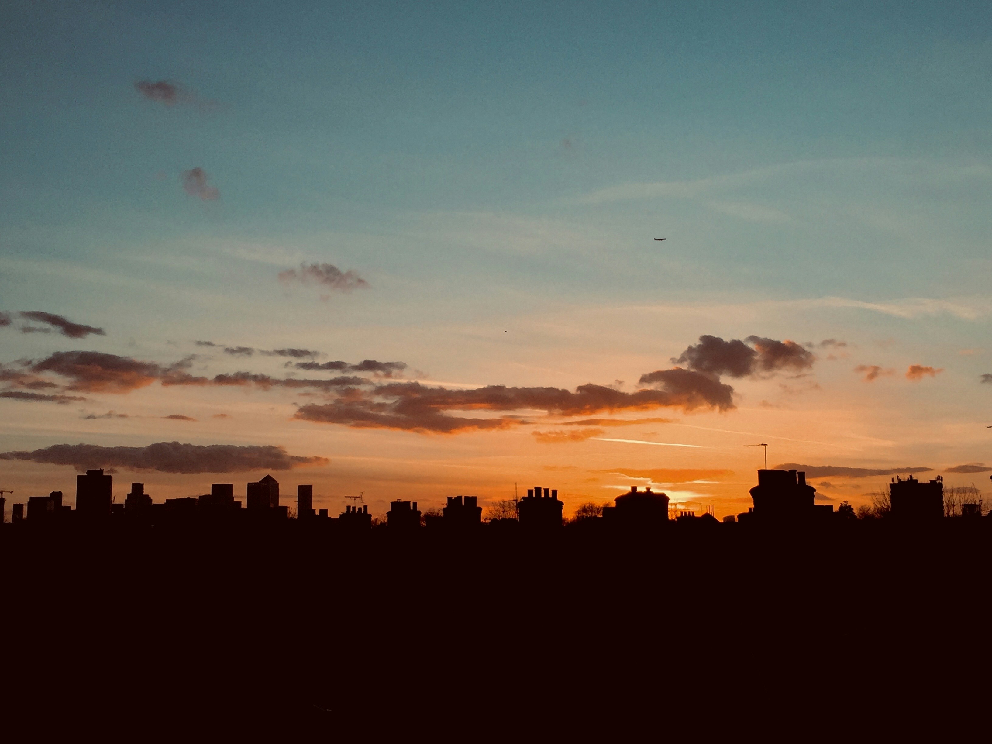 The sun is setting over a city skyline photo – Free Sunset Image on ...