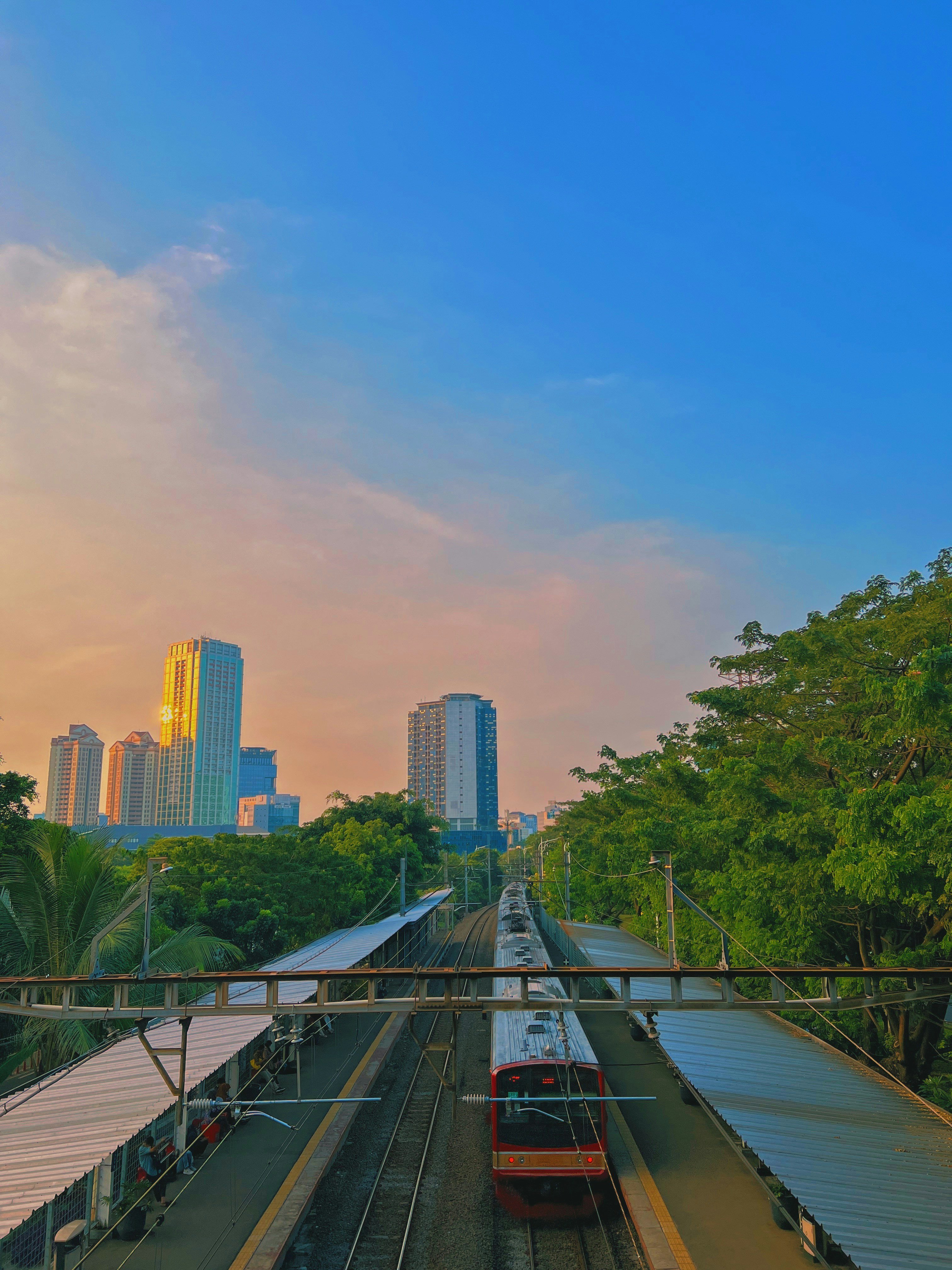A train traveling down train tracks next to tall buildings photo – Free ...
