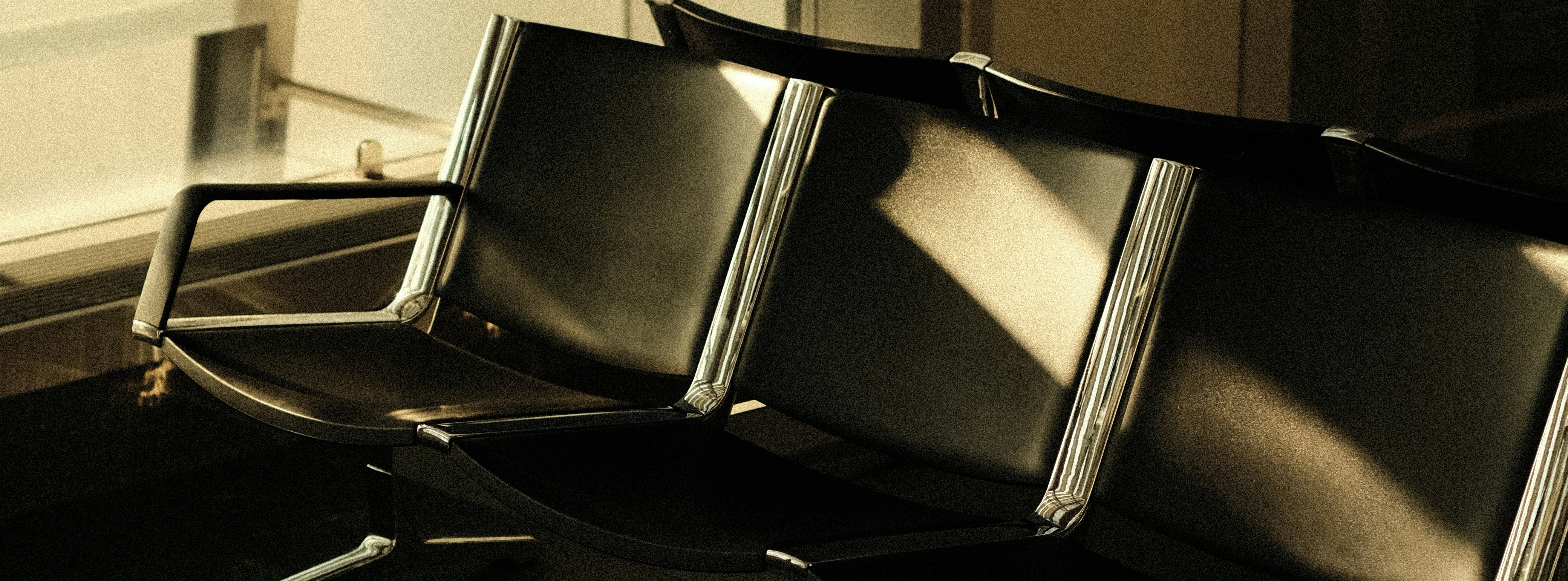 Angles of Quiet Light: Sunlit Leather Chairs in a Silent Terminal