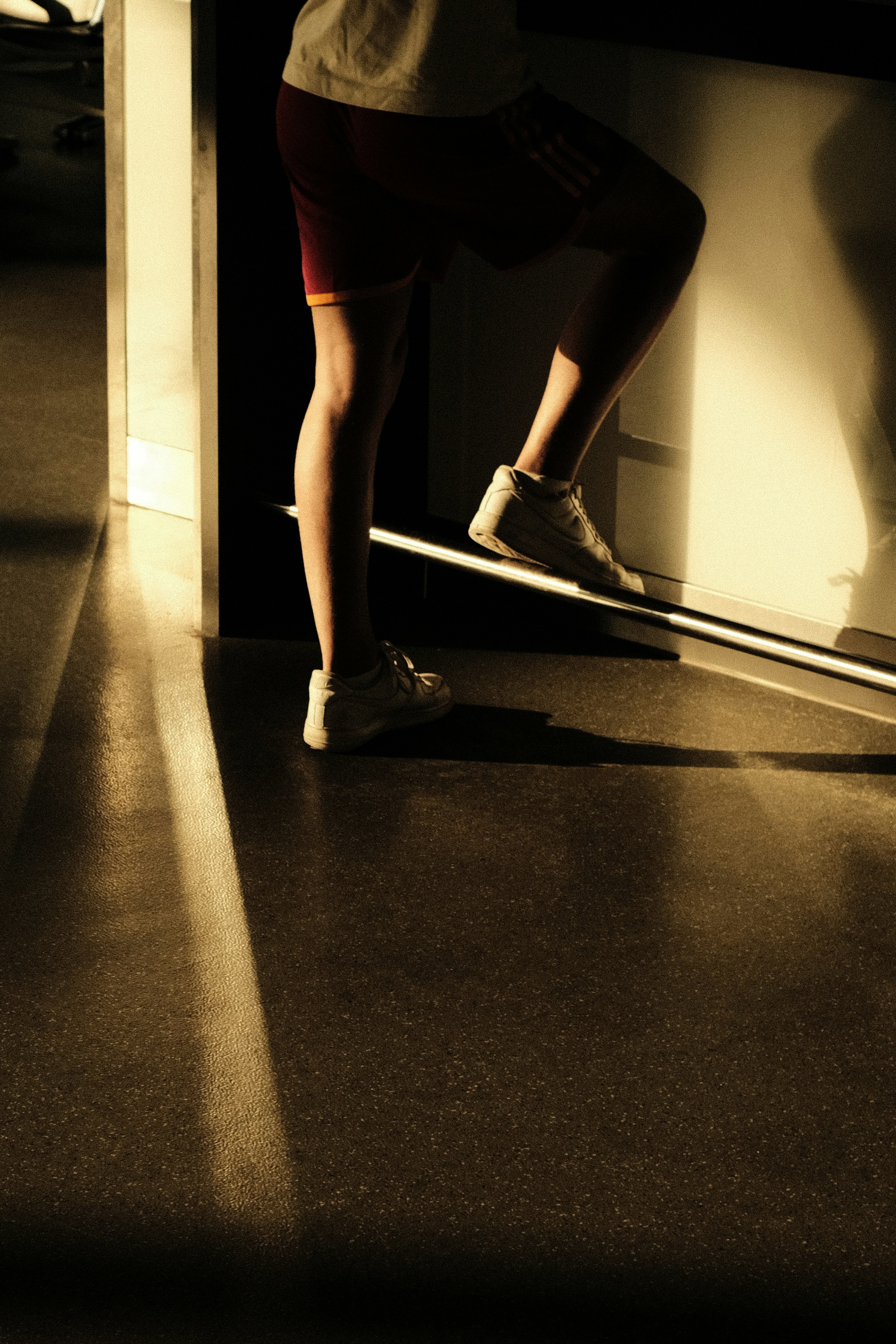Stride Through Warm Shadows: A Quiet Moment in a Dim Corridor