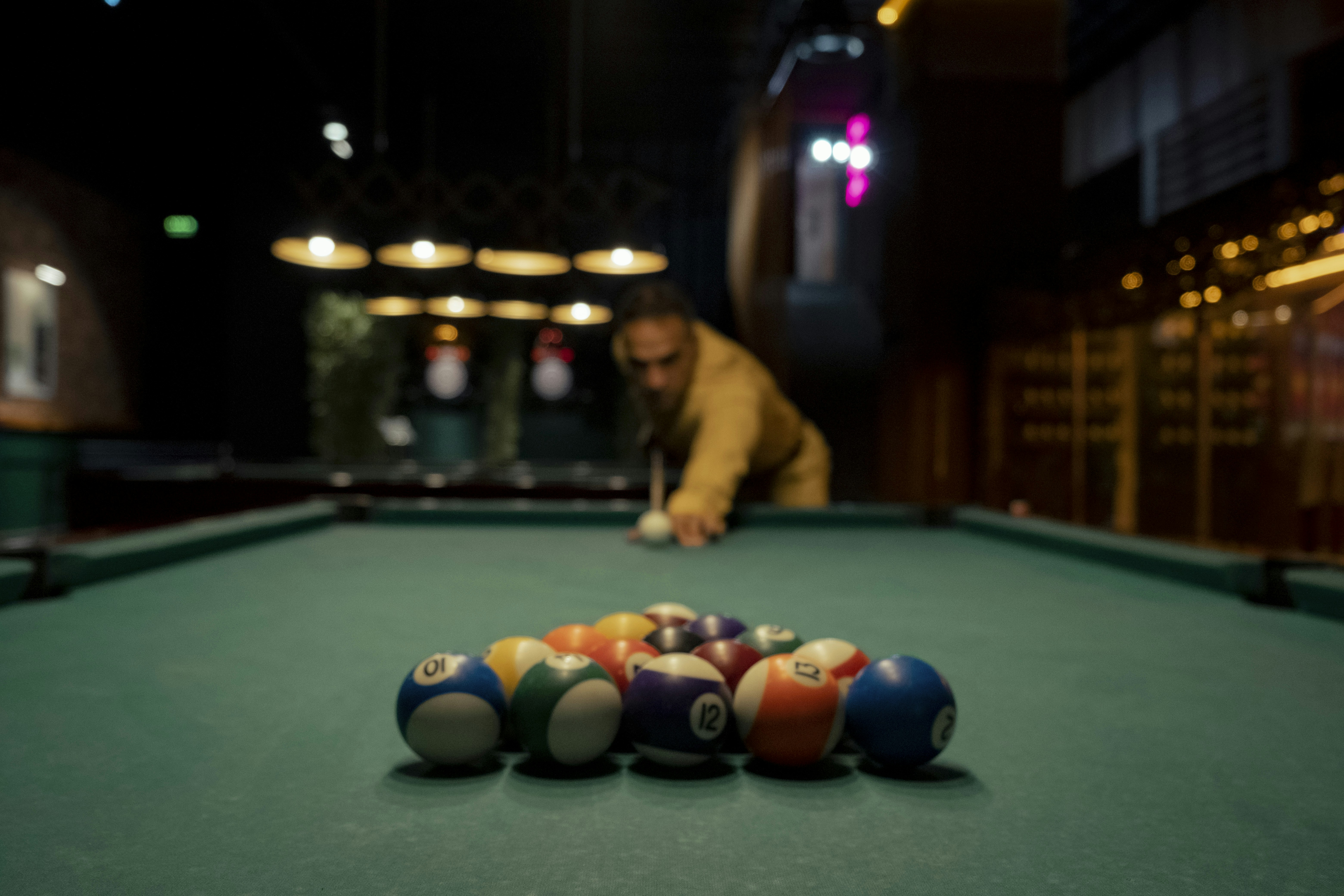 A man leaning over a pool table with eight balls photo – Free Boy Image ...