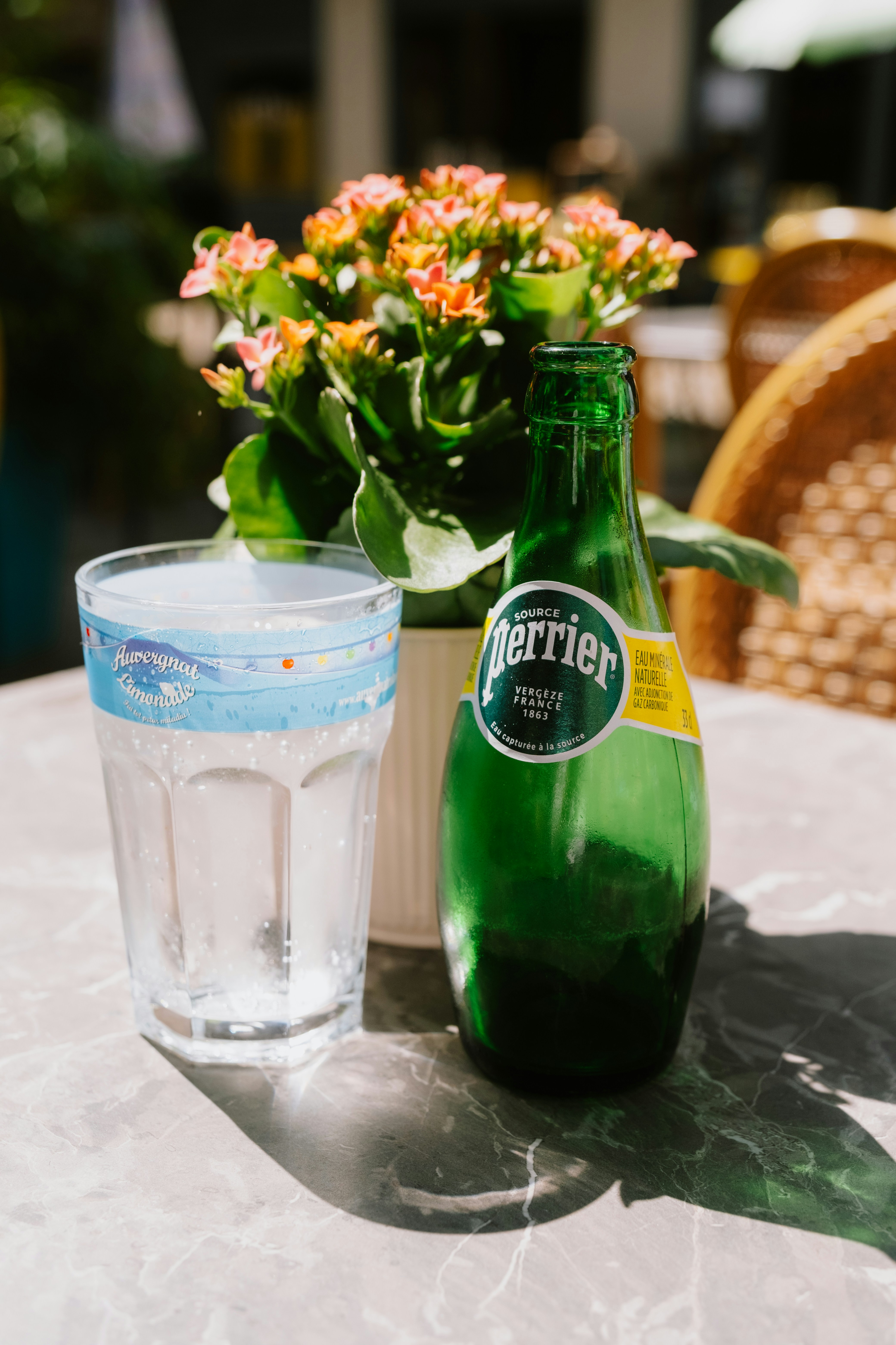 Sunlit Bistro Moment: Perrier bottle and glass in a quiet courtyard