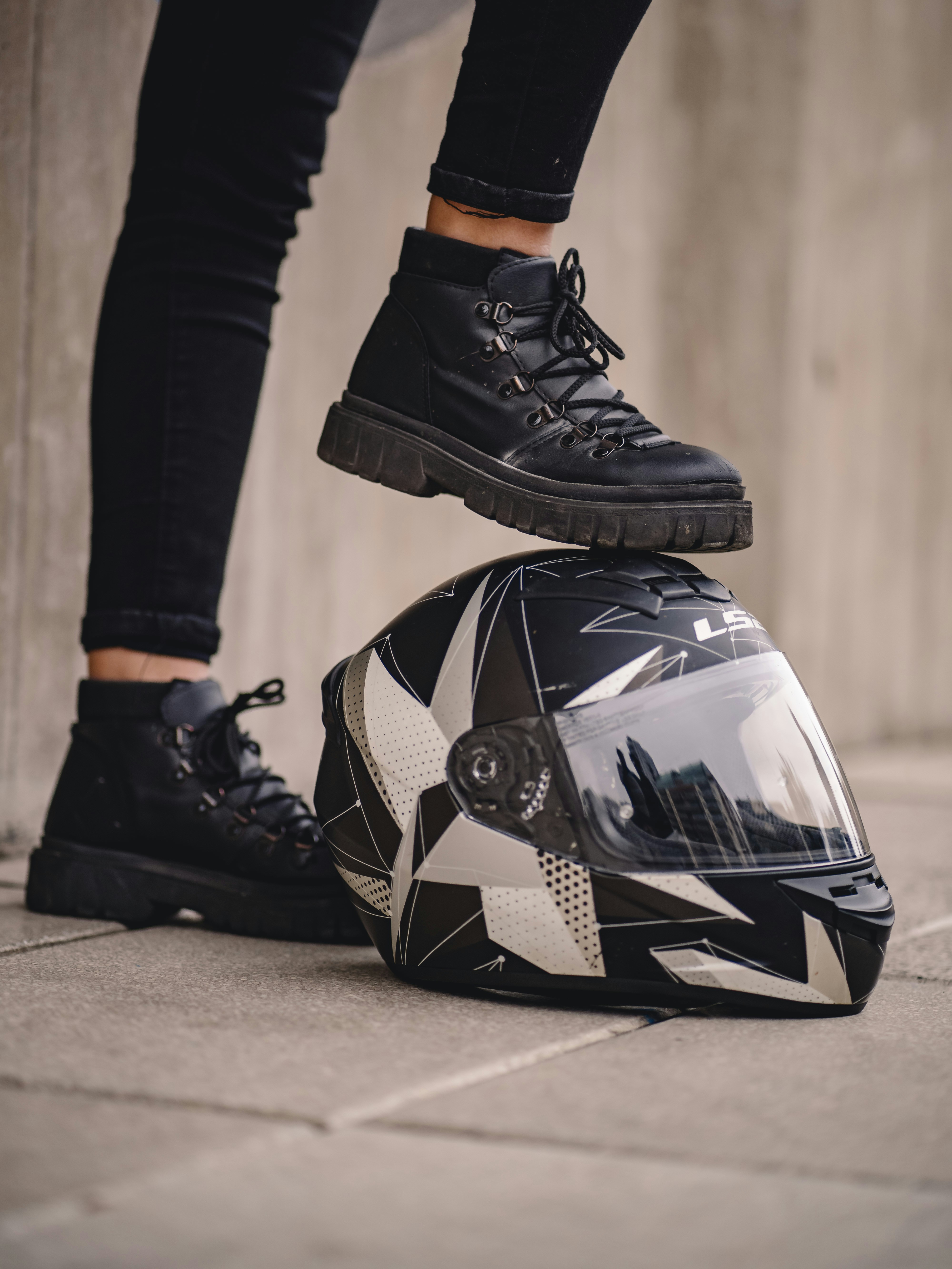 Boots Pin the Faceted Helmet: A Quiet Moment on Concrete