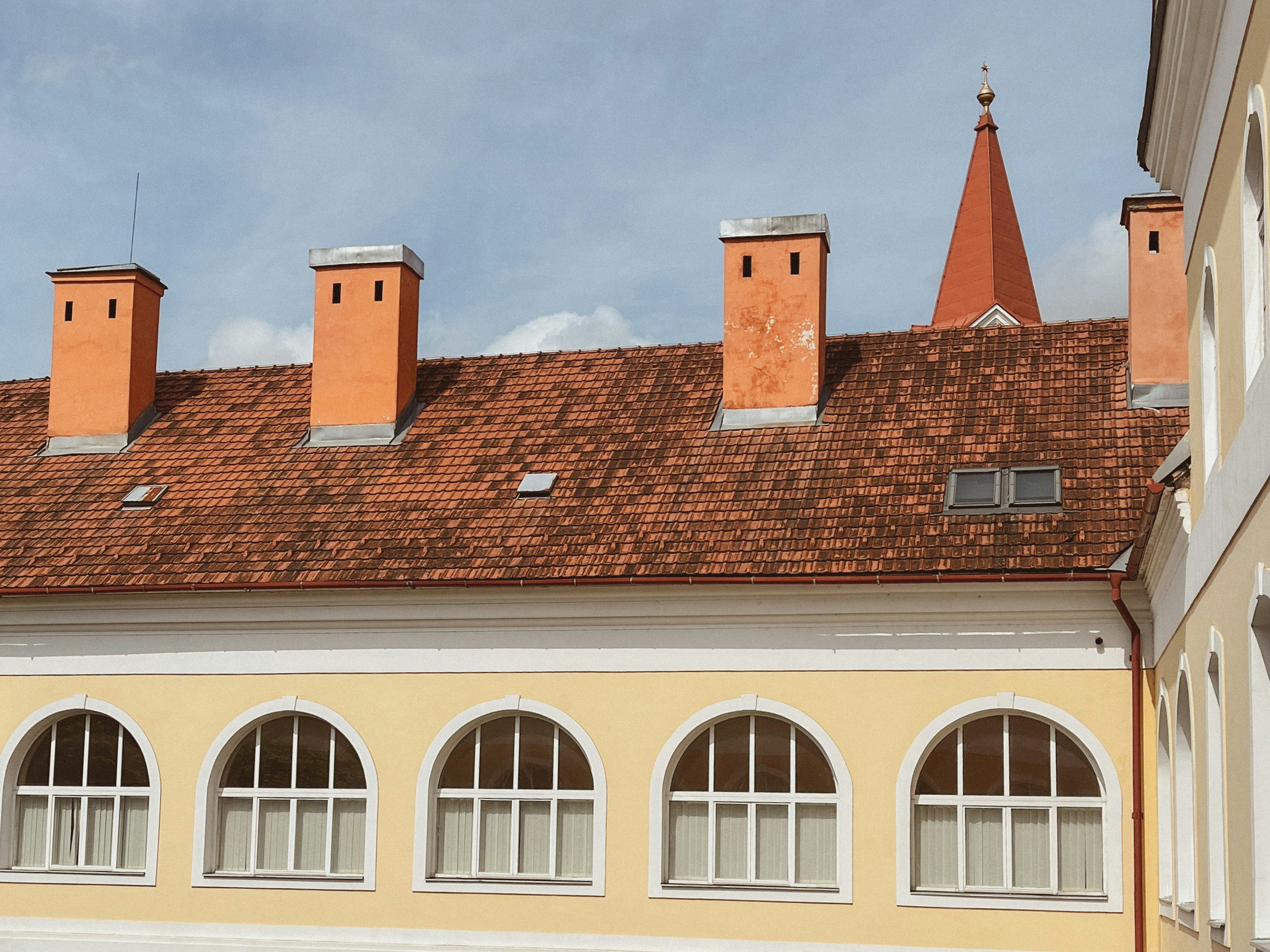 A row of windows on top of a building photo – Free Building Image on ...