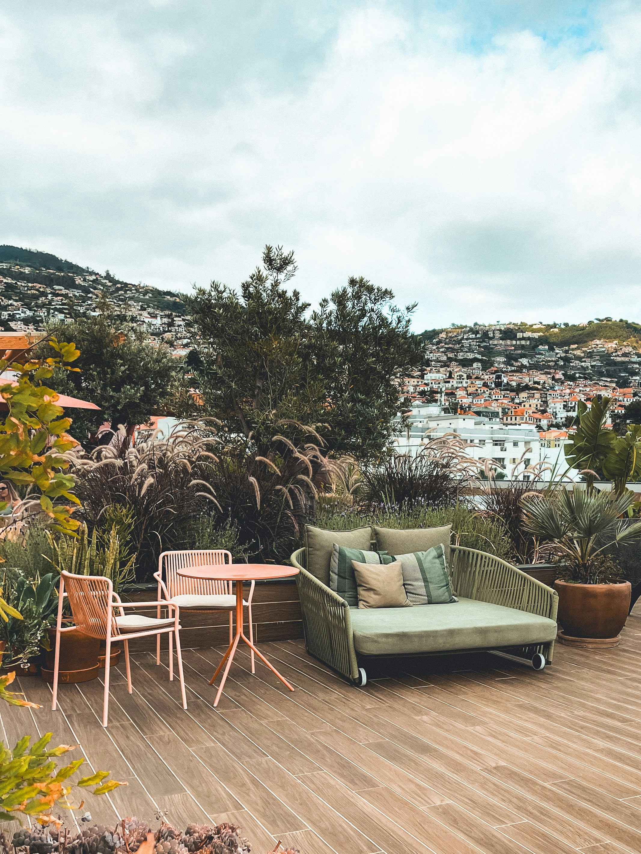 Stylish outdoor seating area adorned with greenery, offering a panoramic view of the city. The blend of natural elements and modern design invites relaxation.