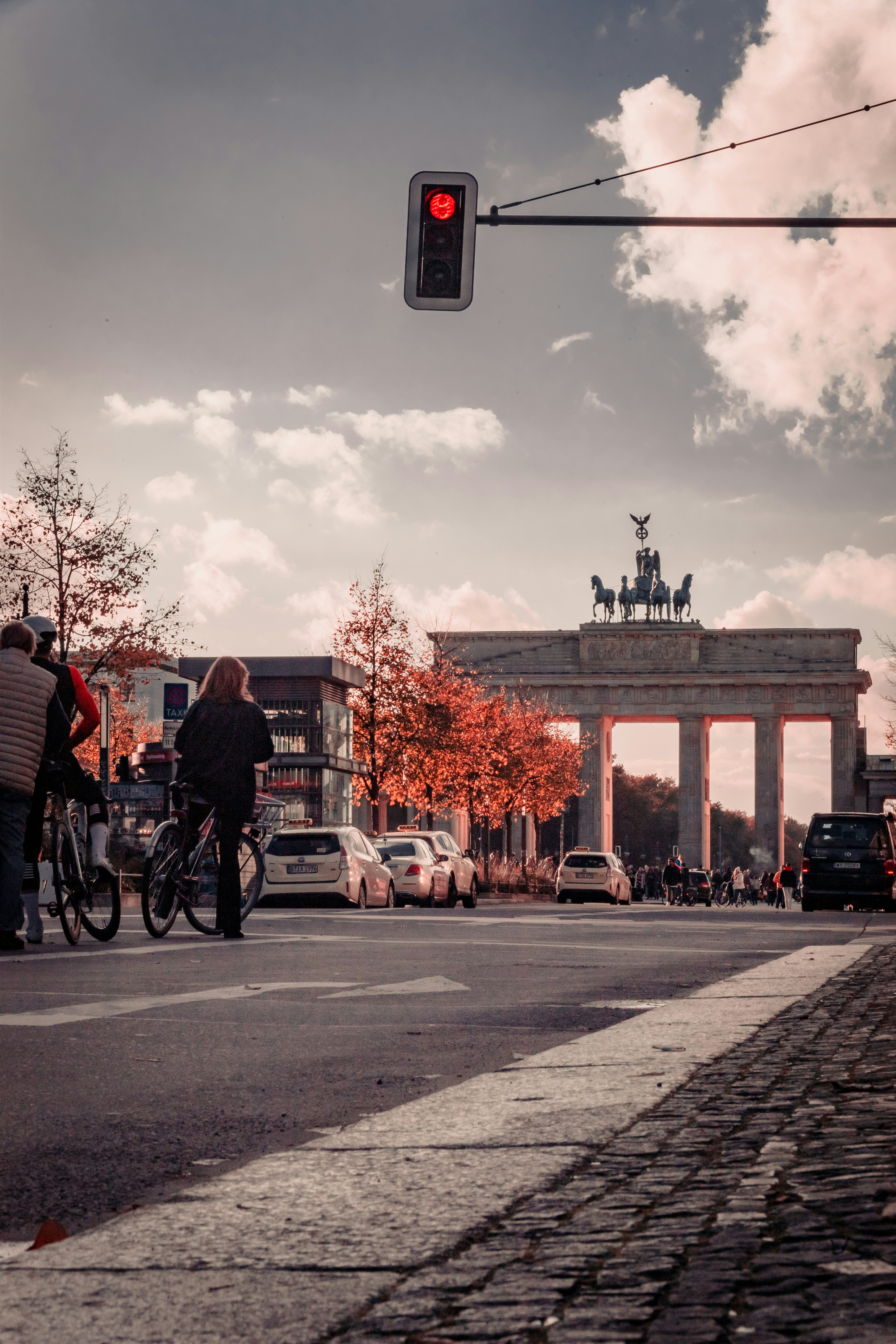 Red Signal Over a Berlin Street Framing the Brandenburg Gate