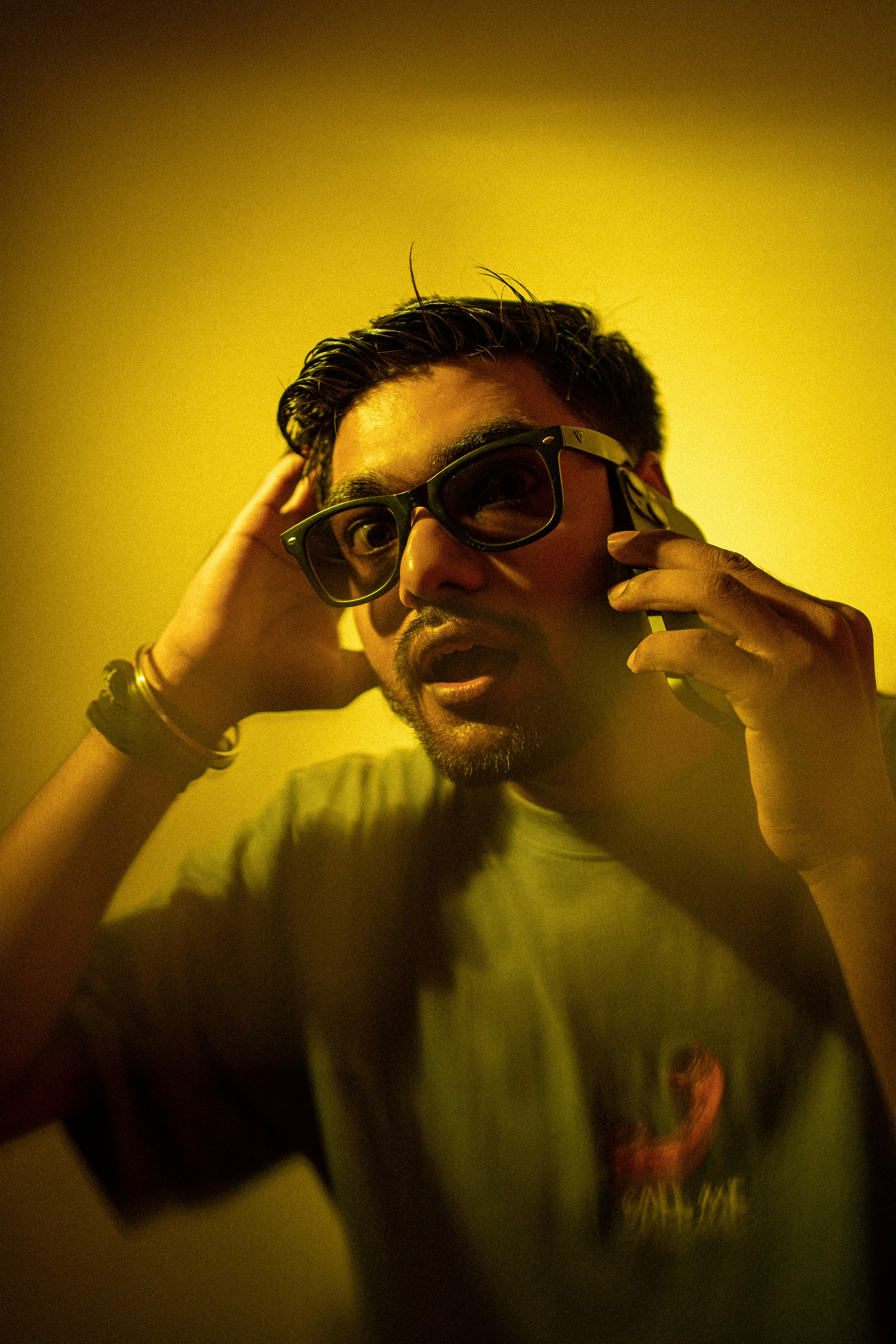 Amber-Glow Moment: A Glasses-Clad Voice Across the Yellow Room