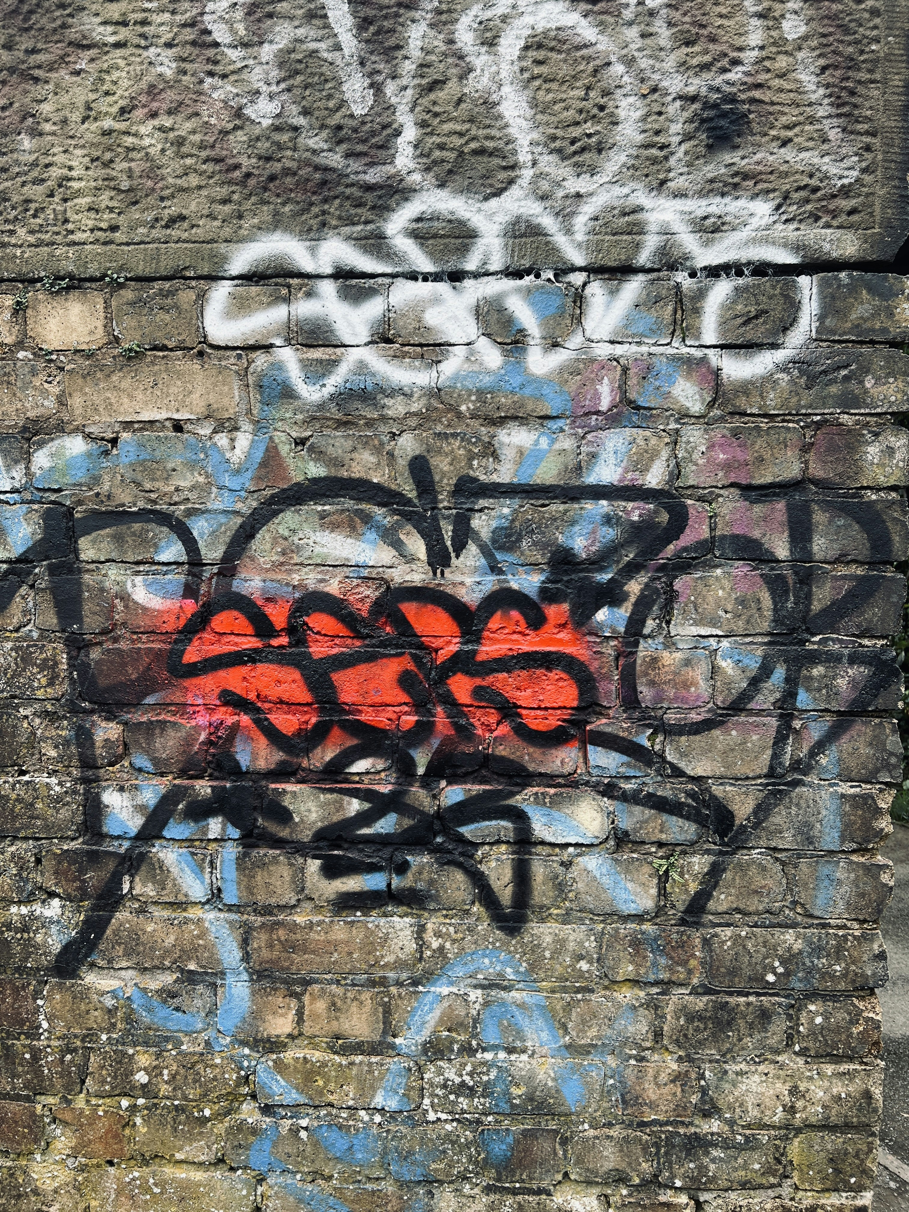 Crimson Graffiti on a Weathered Brick Canvas