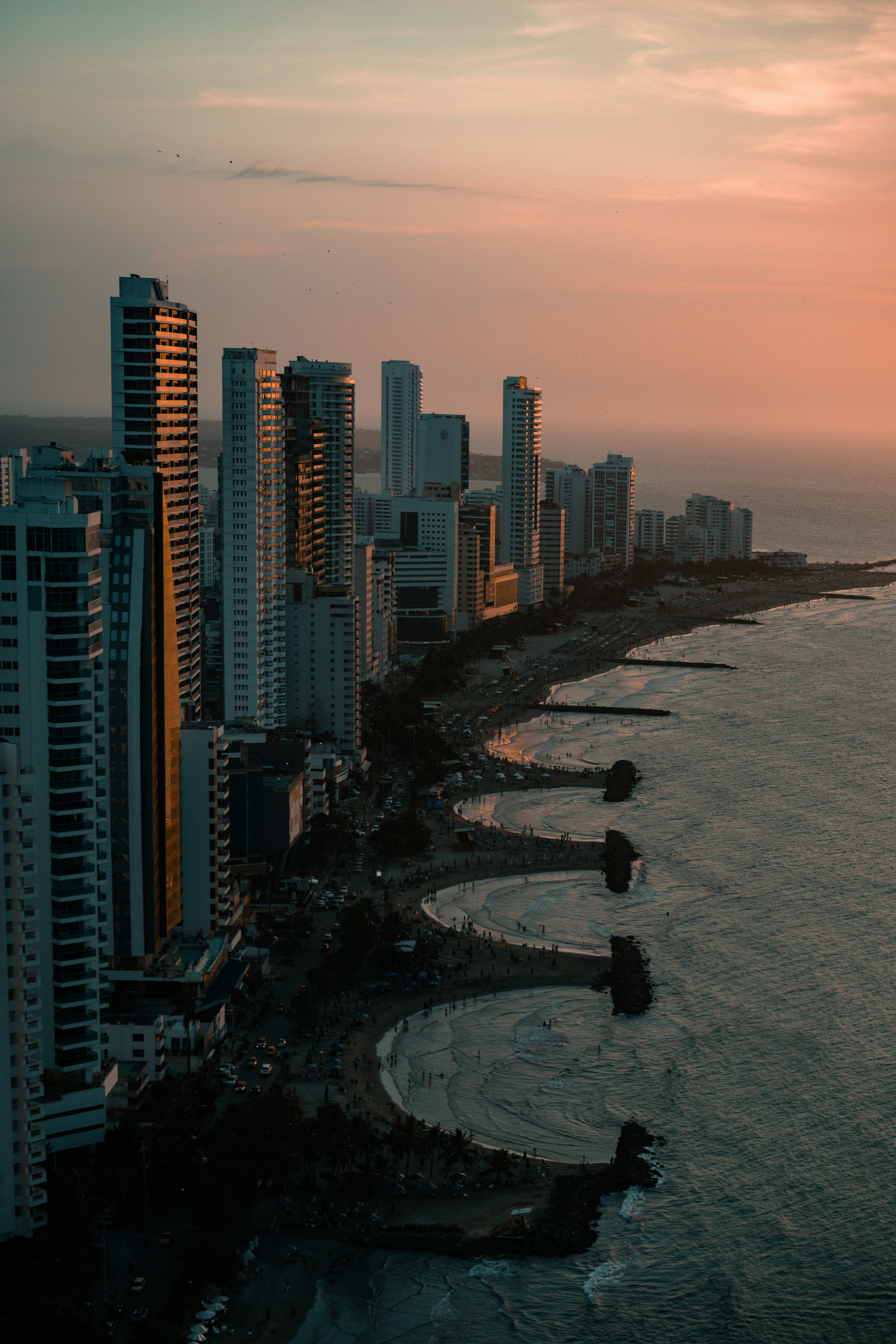 Dusk Spine: High-Rise Silhouette Along a Curved Beachfront