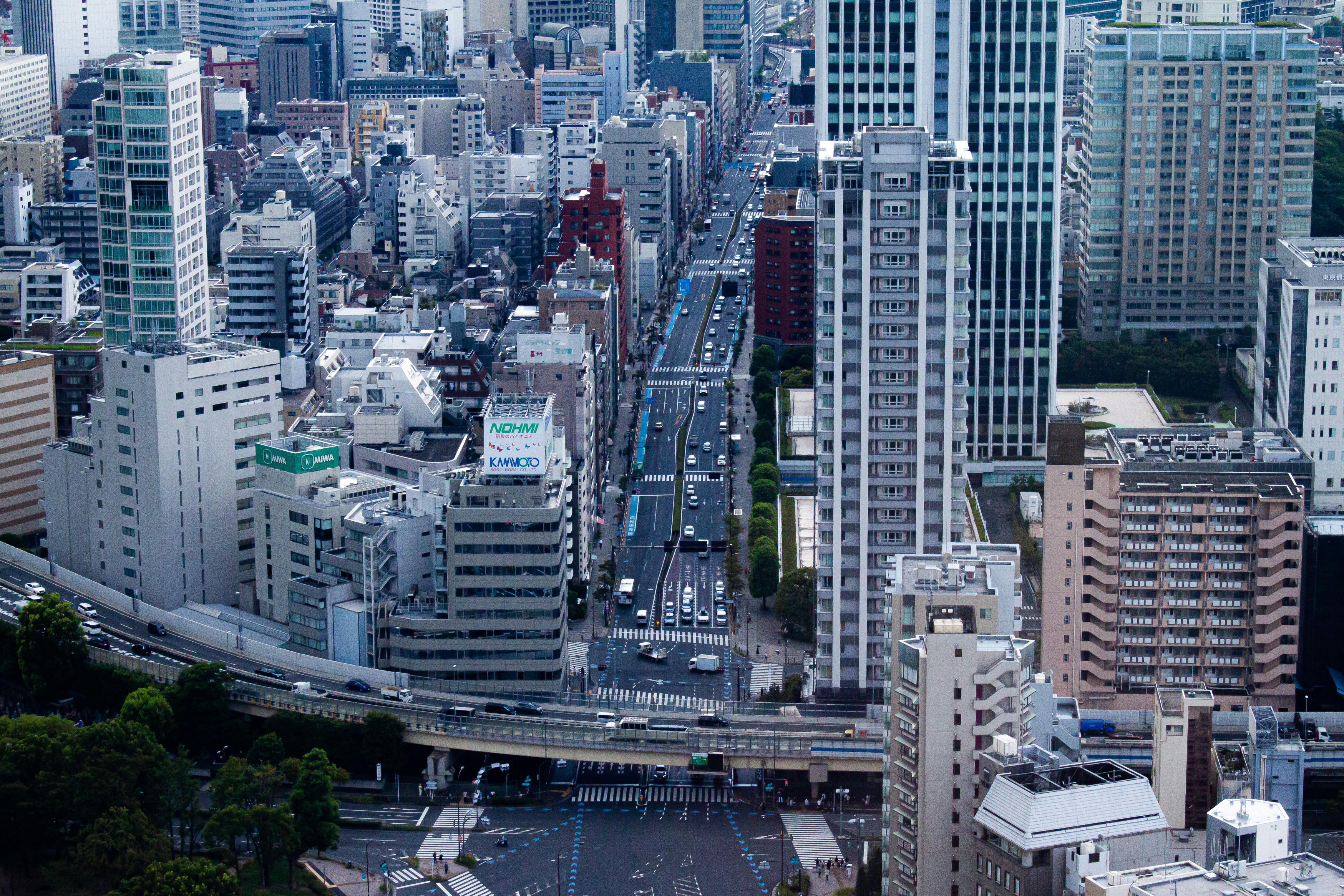 Aerial view of a bustling cityscape, showcasing the intricate network of roads and towering buildings. The scene captures the dynamic rhythm of urban life.