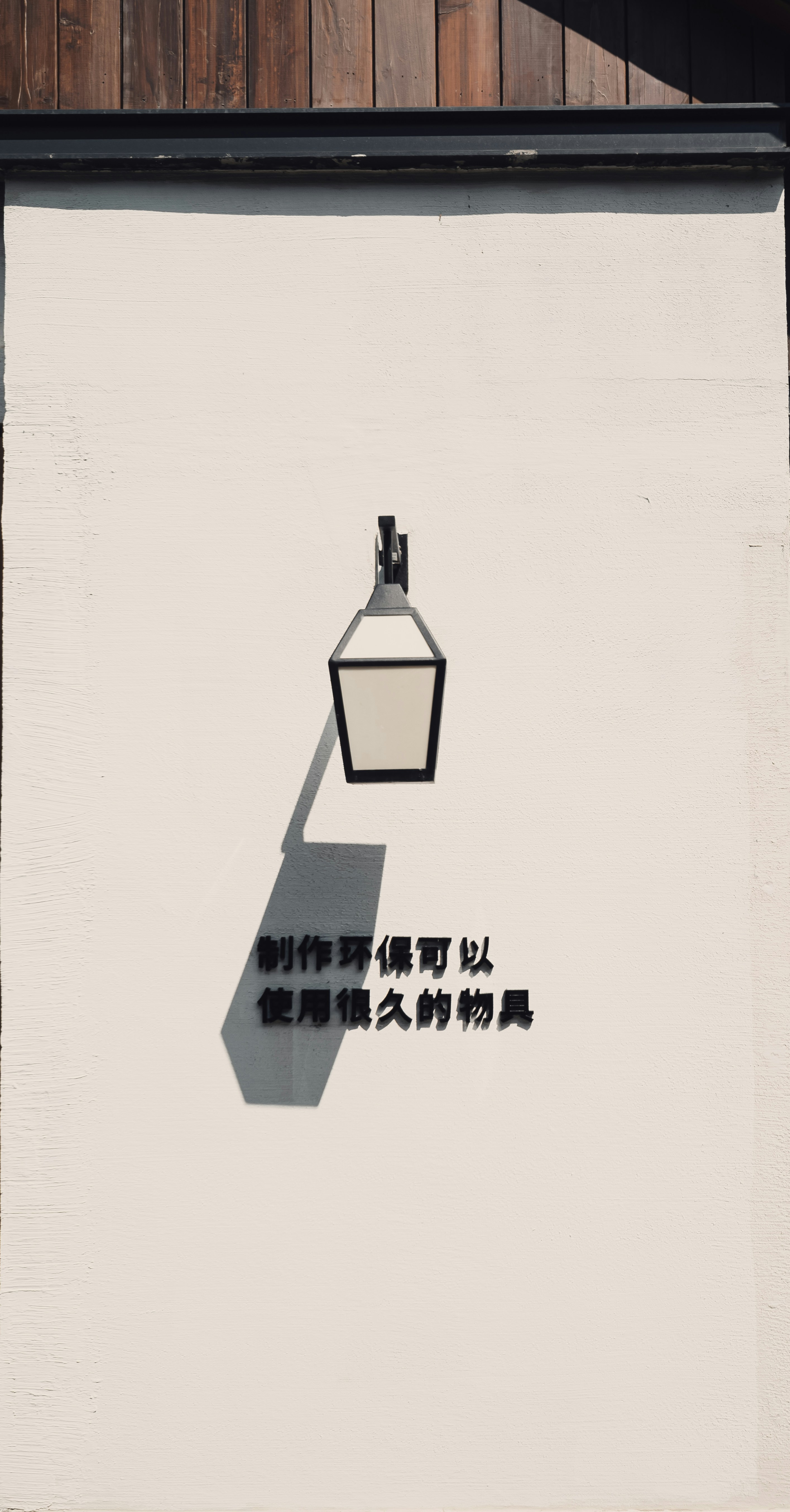 The Lantern and Its Long Shadow on a Quiet White Wall
