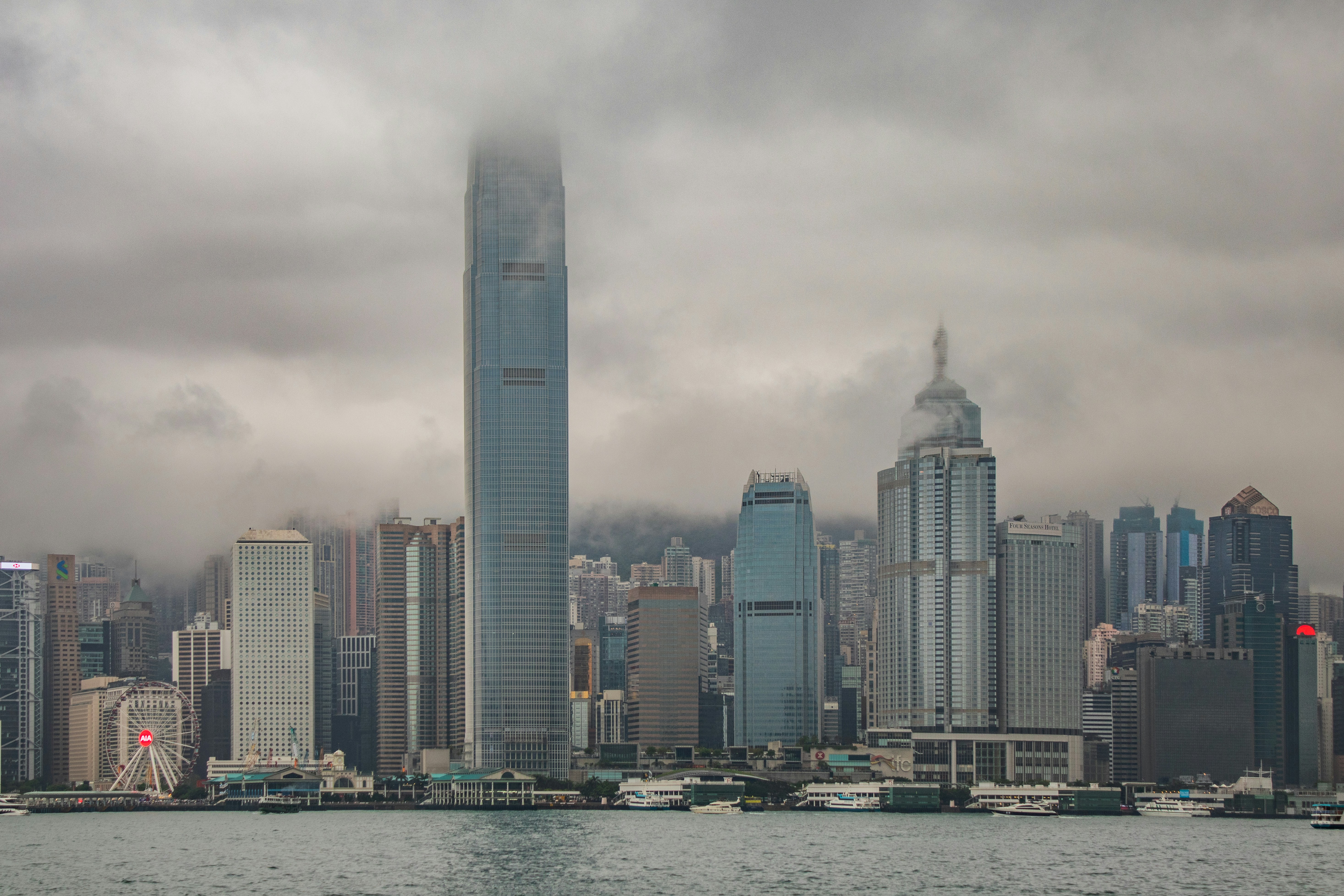 A very tall building towering over a large body of water photo – Free ...