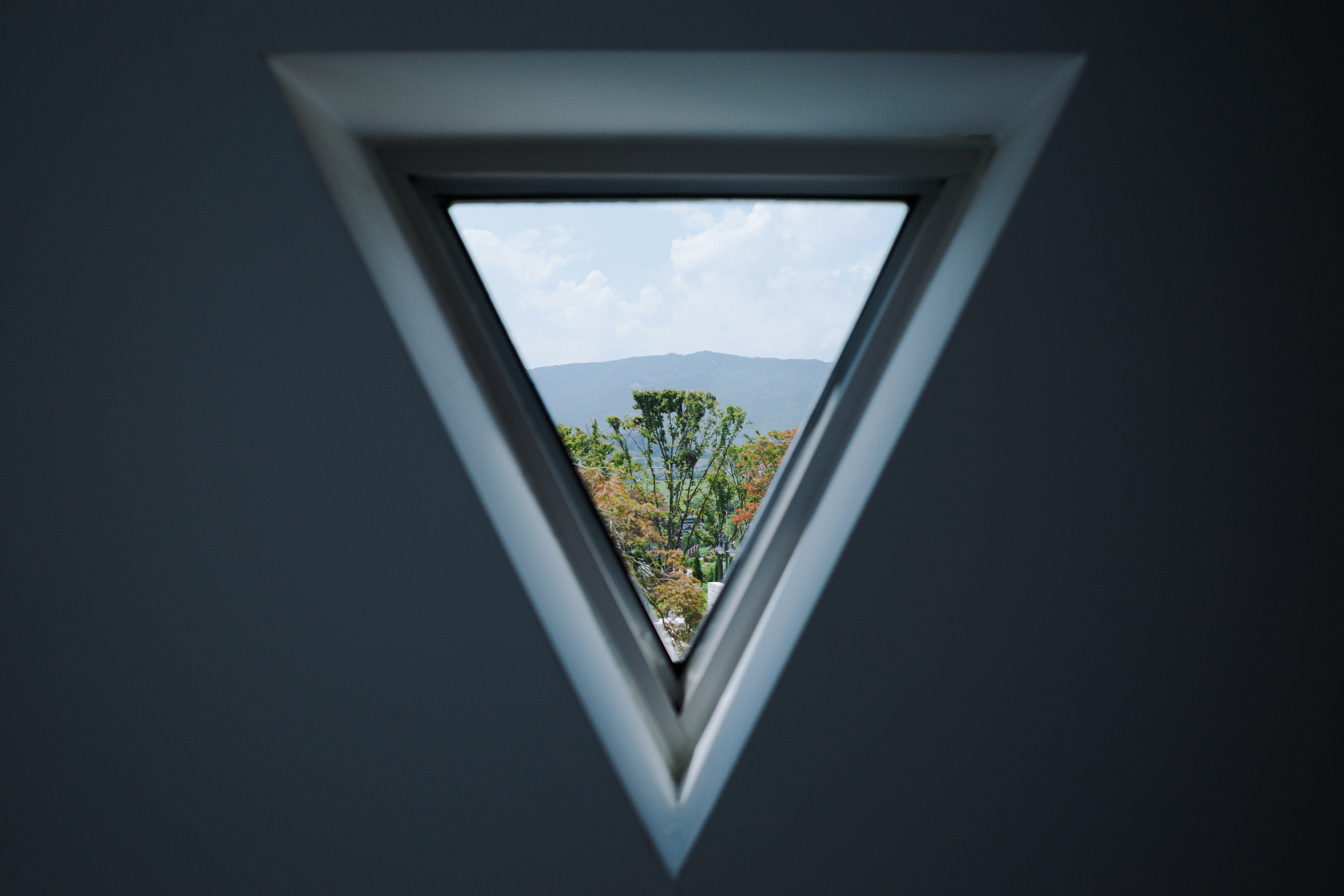 Una ventana en forma de triángulo con vistas a una montaña foto – Imagen de Arquitectura ...